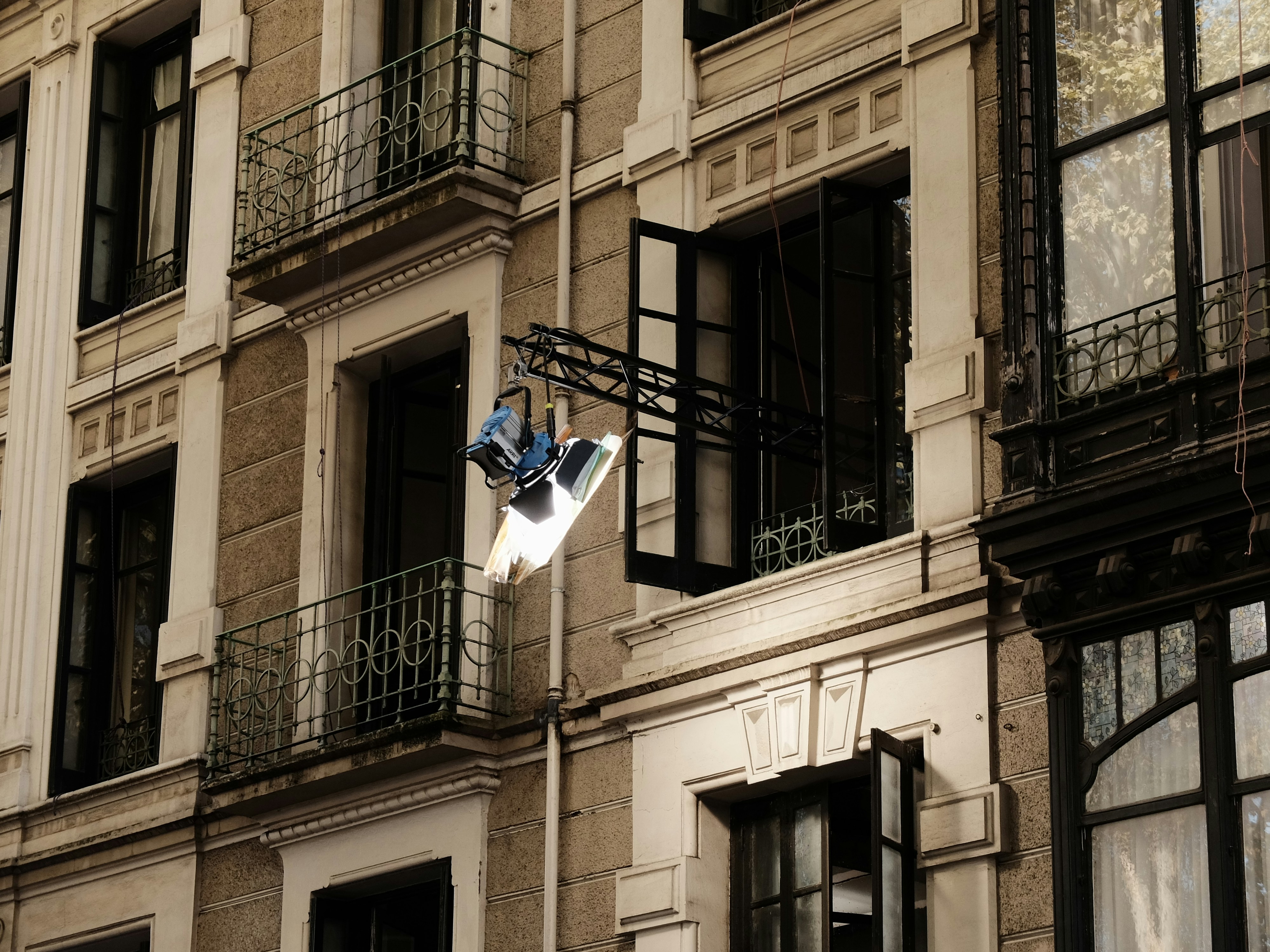 Urban Window Moment: A Rooftop Light Stand Surfaces Above an Old Street