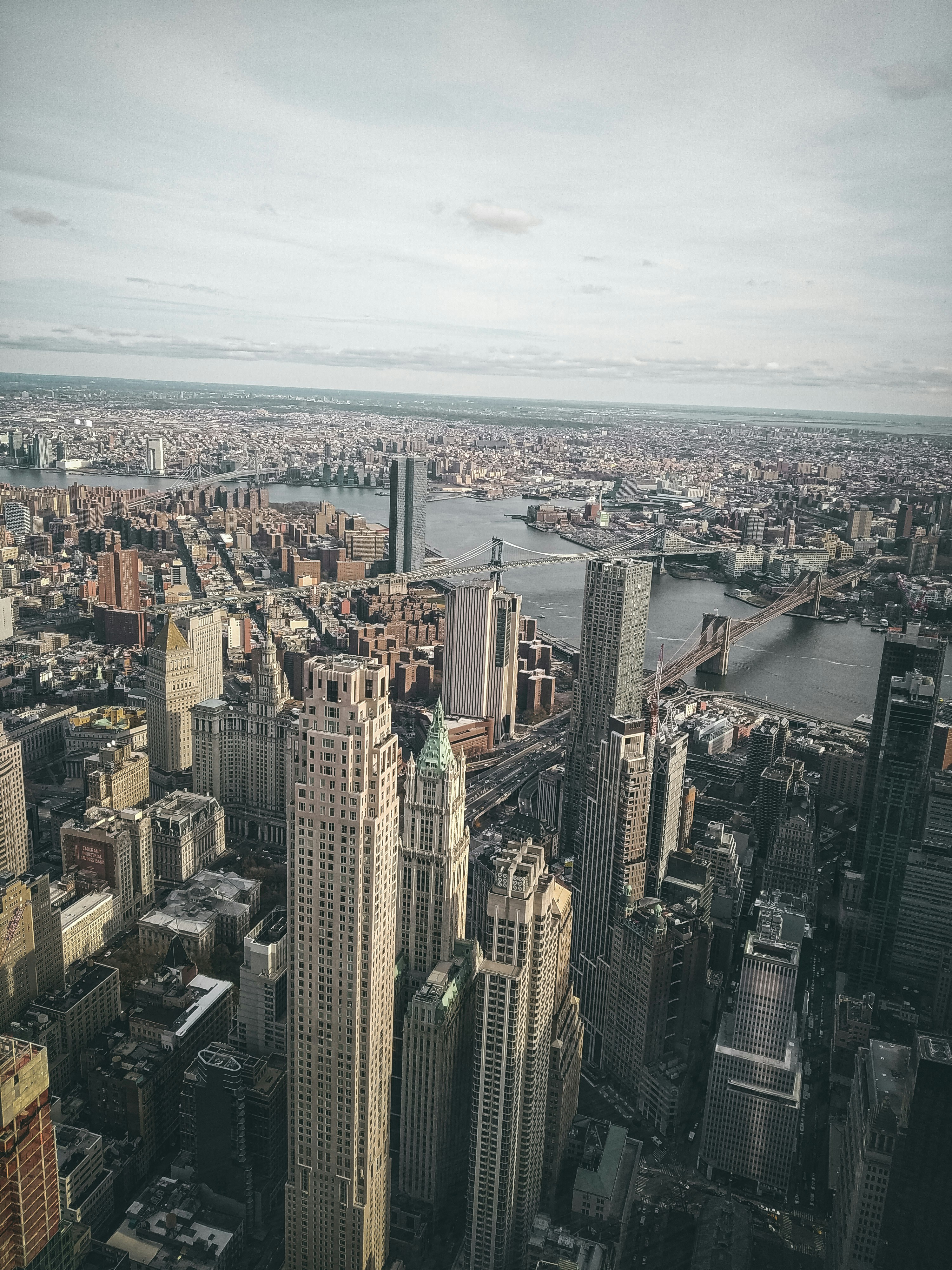 Aerial view of a bustling city, showcasing towering skyscrapers and a winding river, with bridges connecting vibrant urban areas.