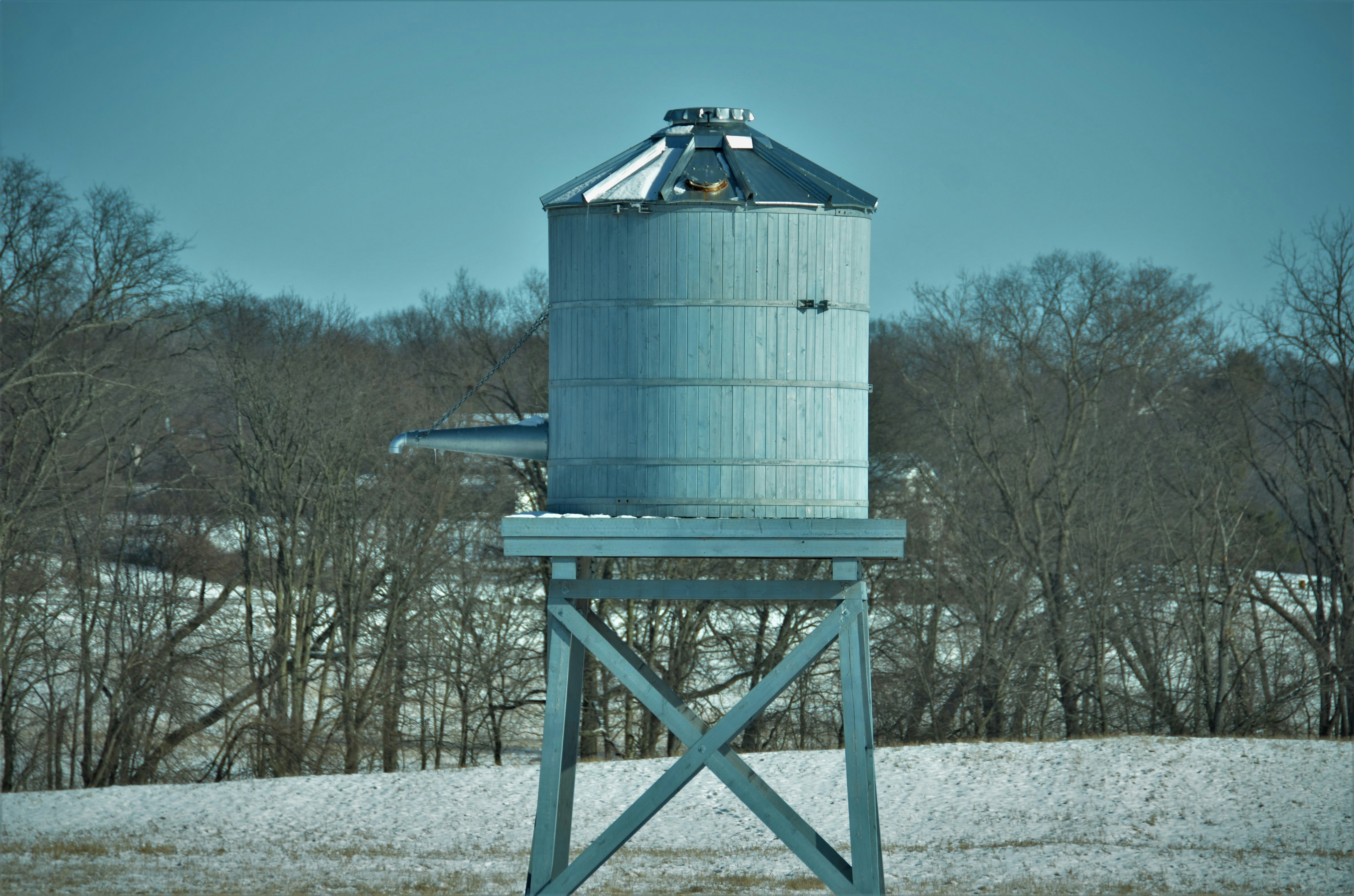 A large metal silo sitting in the middle of a field photo – Free Water ...
