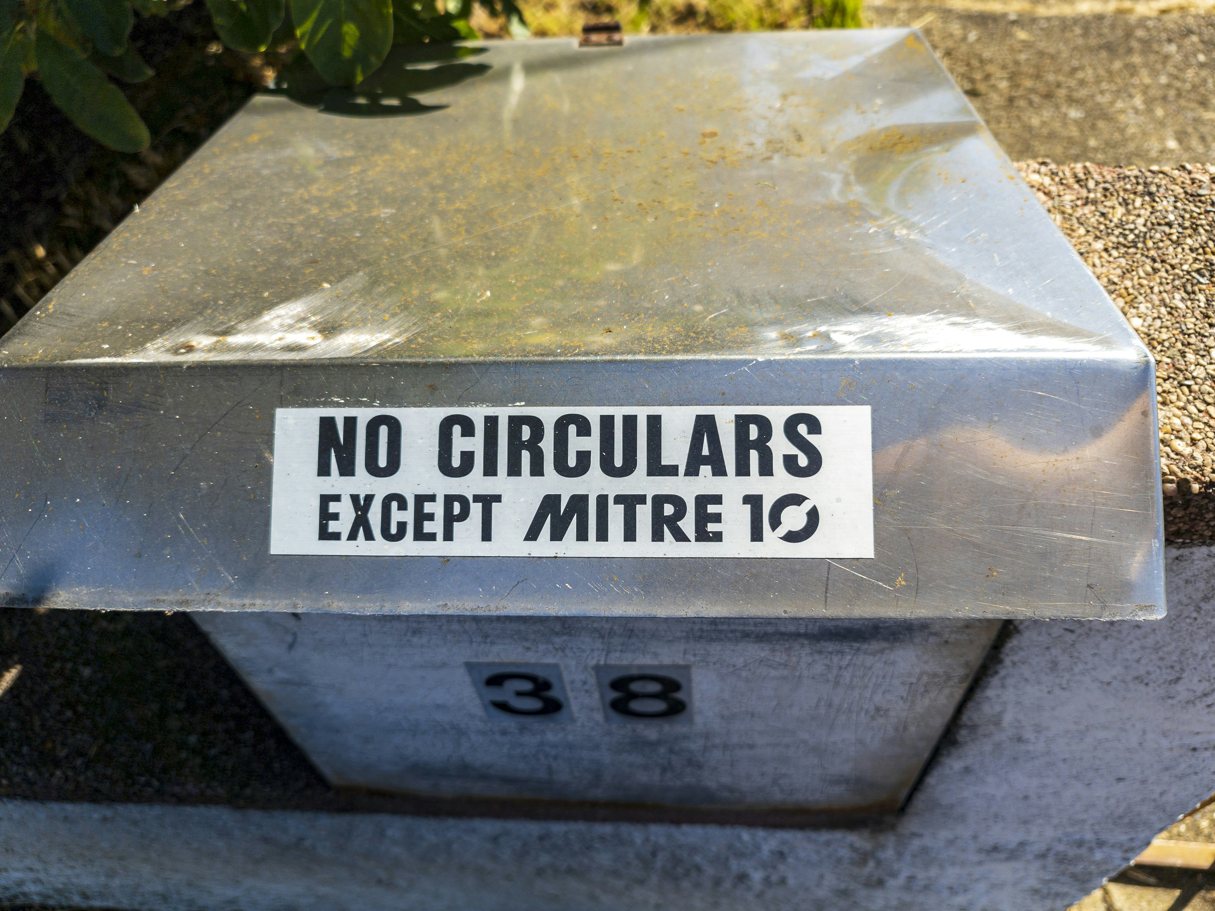 No Circulars Except Mitre 10: Weathered Metal Utility Box in Daylight