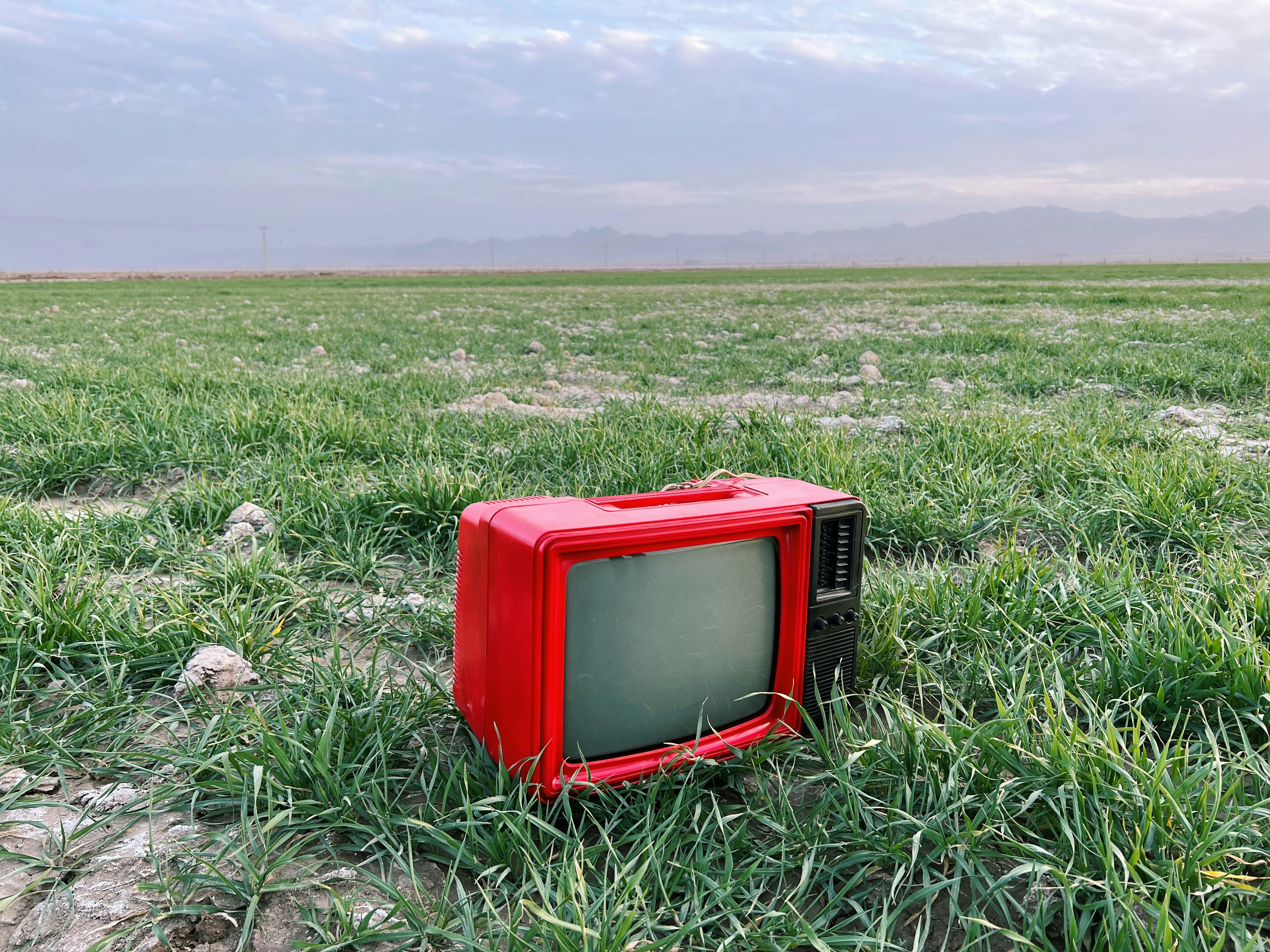 A red television sitting in the middle of a field photo – Free Red ...