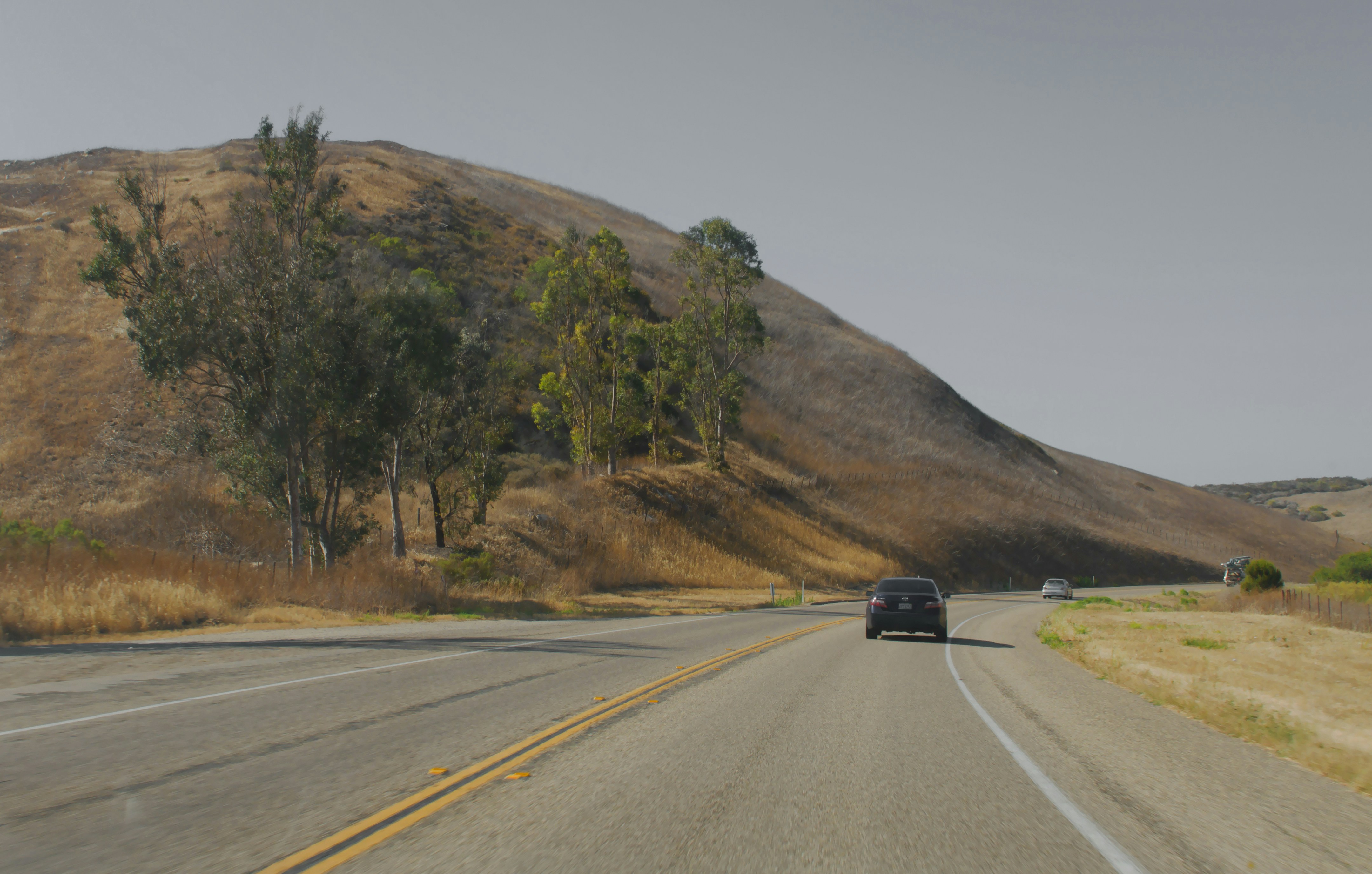 A car driving down a road next to a mountain photo – Free Usa Image on ...