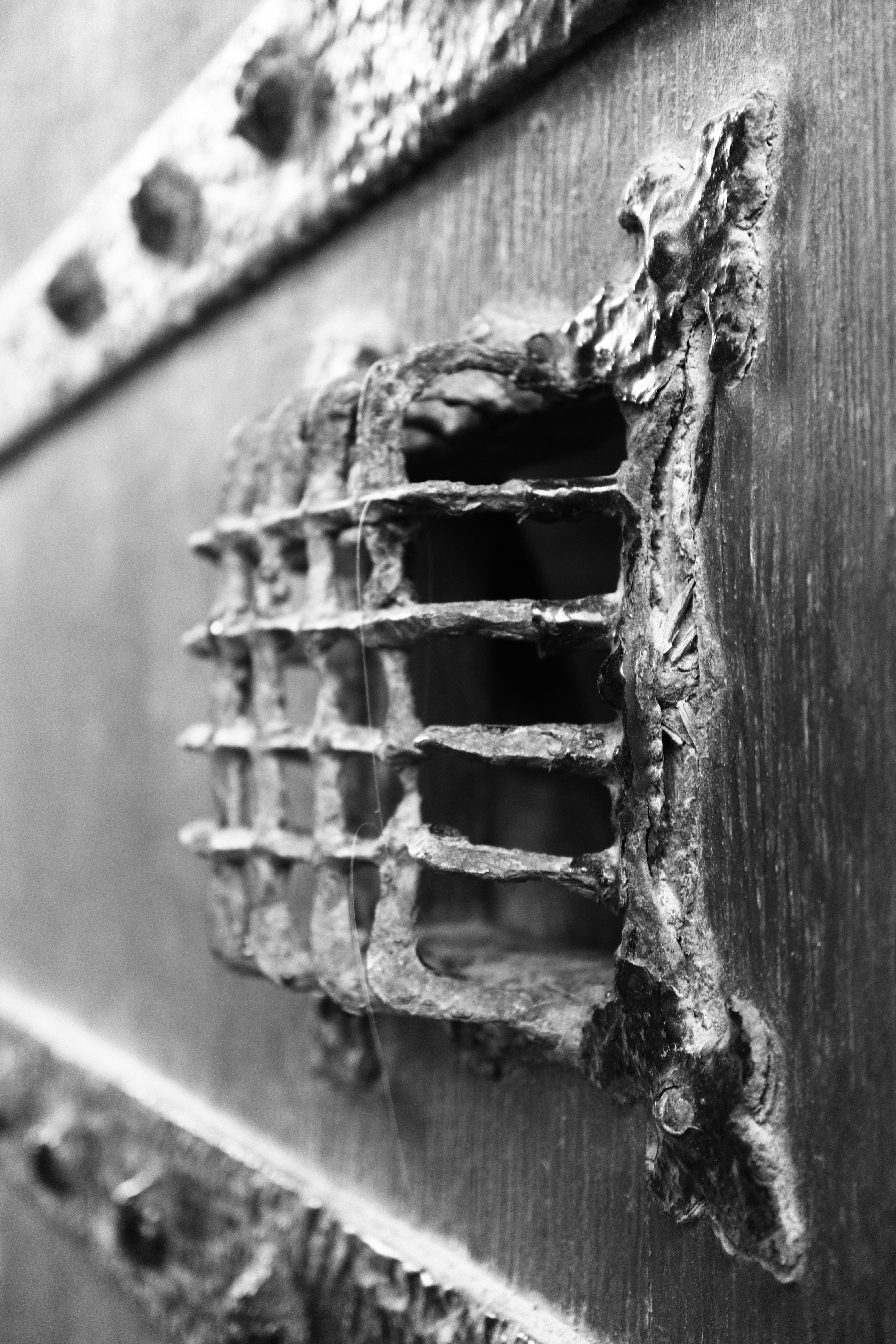 Time-Worn Lattice: Close-Up of a Rusted Vent Grate on Weathered Surface