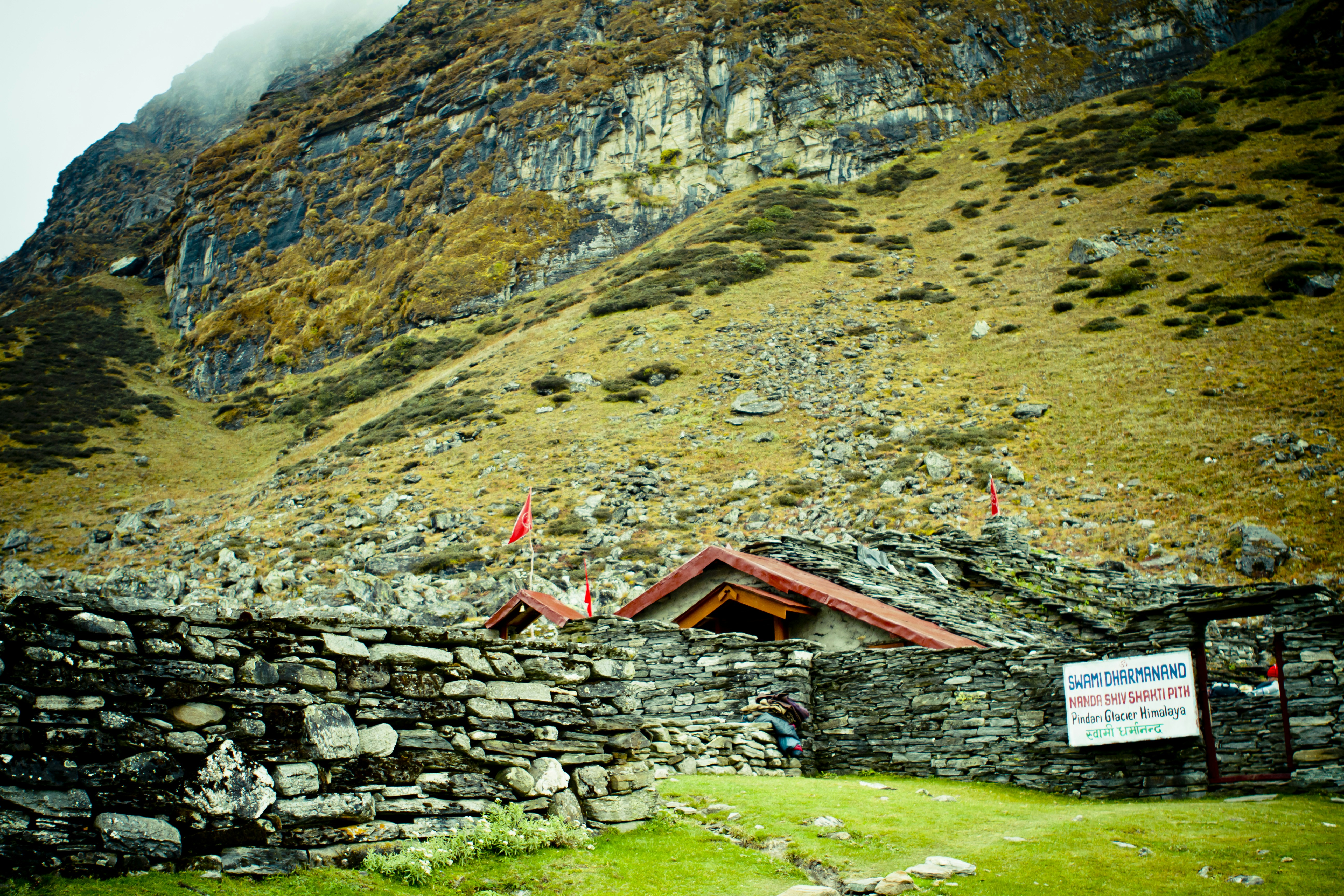 Stone Wall Gateway into Alpine Shelter under Misty Peak