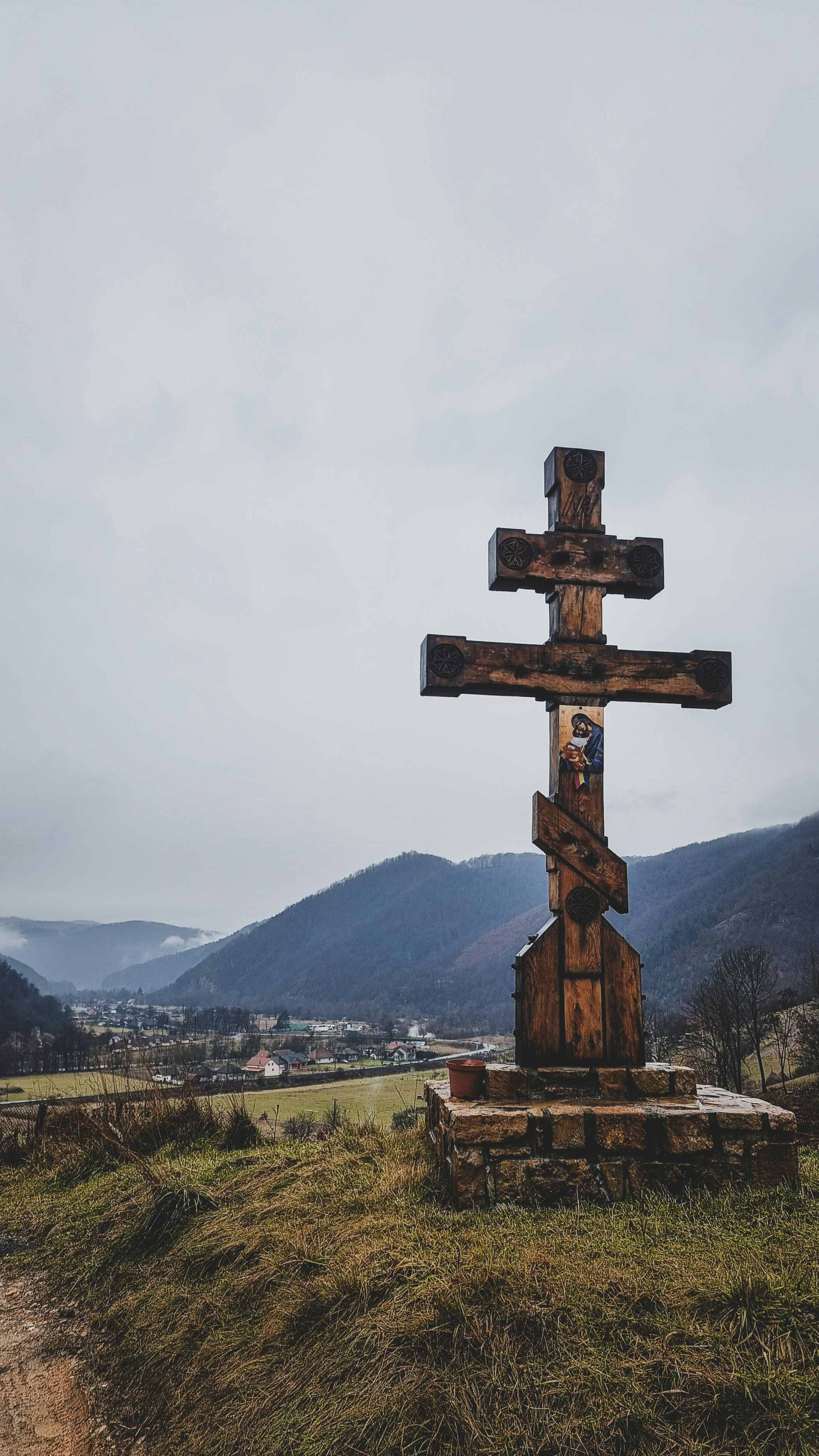 A wooden cross sitting on top of a lush green field photo – Free ...