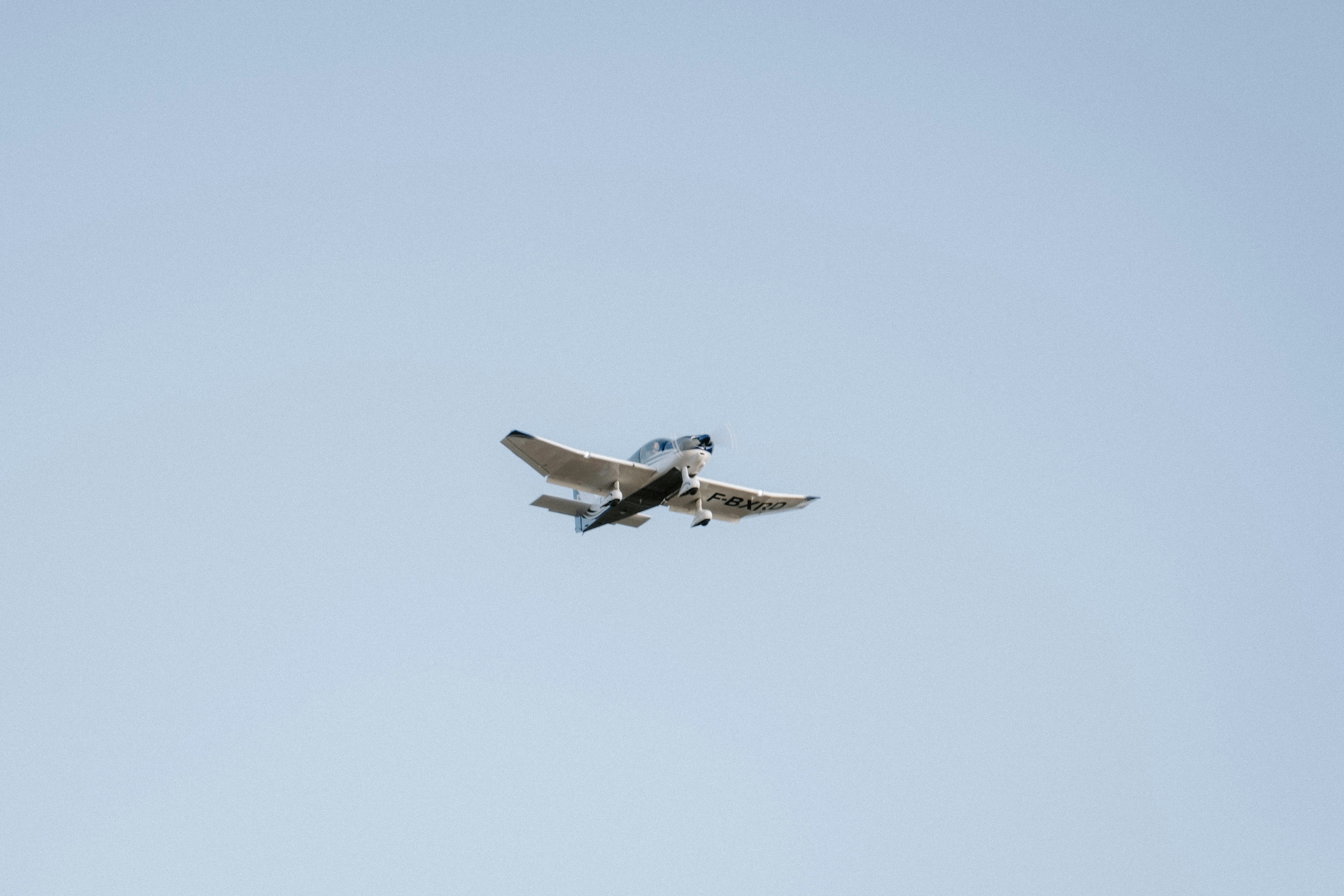 a small plane flying through a blue sky