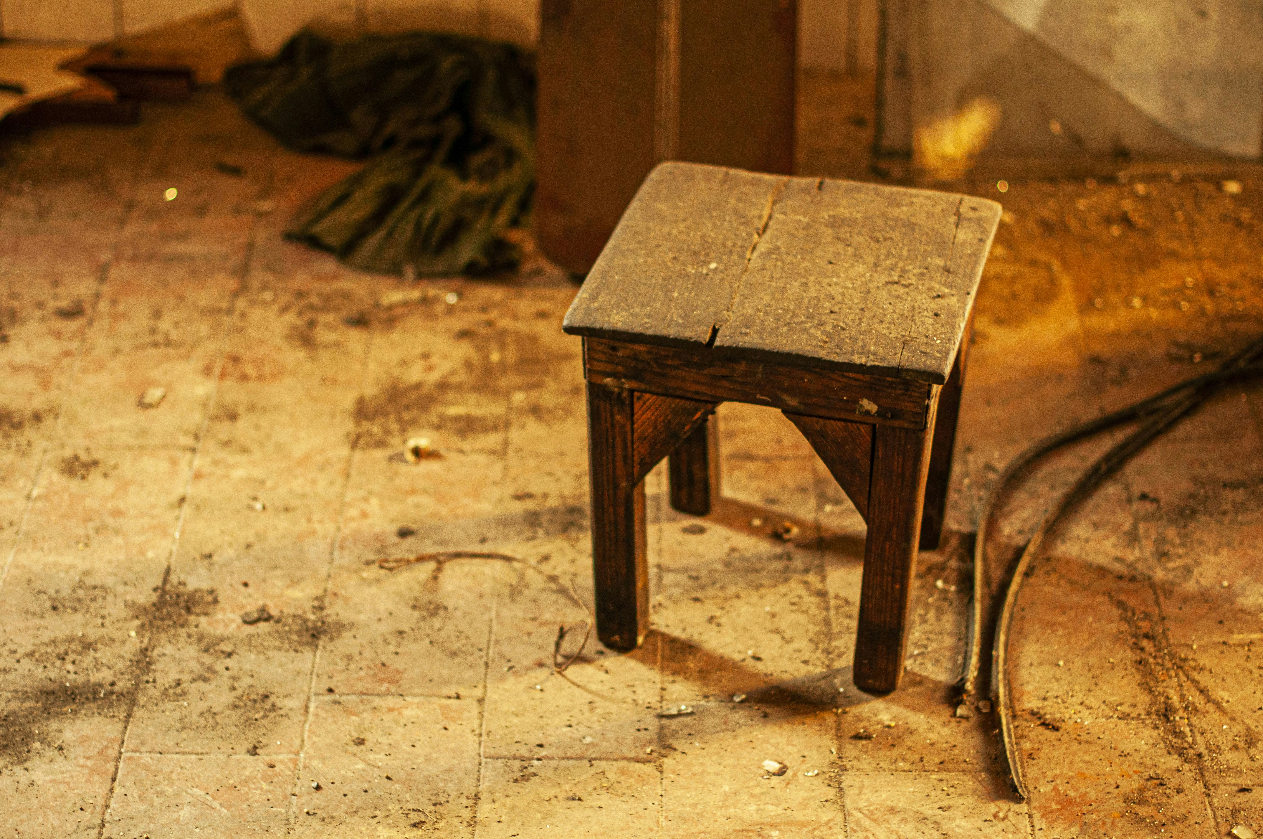 Amber Light and Worn Wood: A Stool in a Dusty Workshop