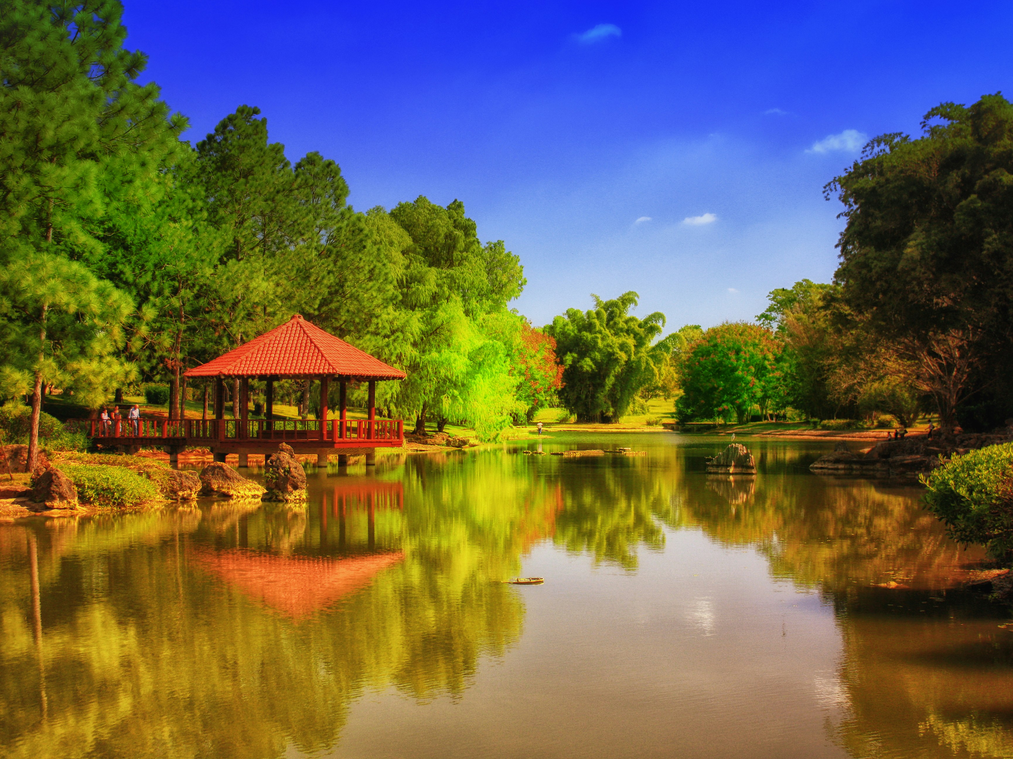 a gazebo in the middle of a lake surrounded by trees