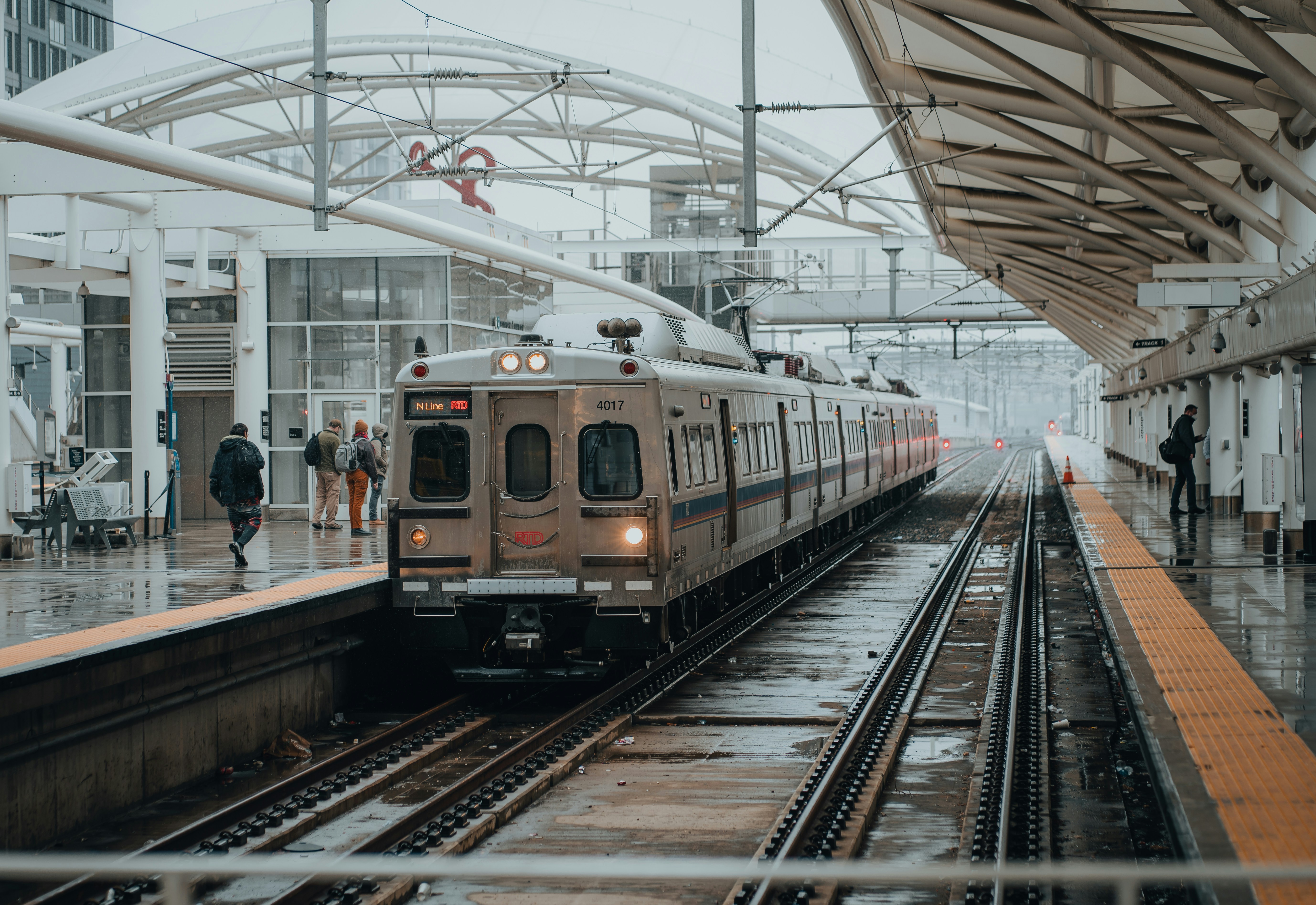 Un train entrant dans une gare un jour de pluie photo – Photo États ...