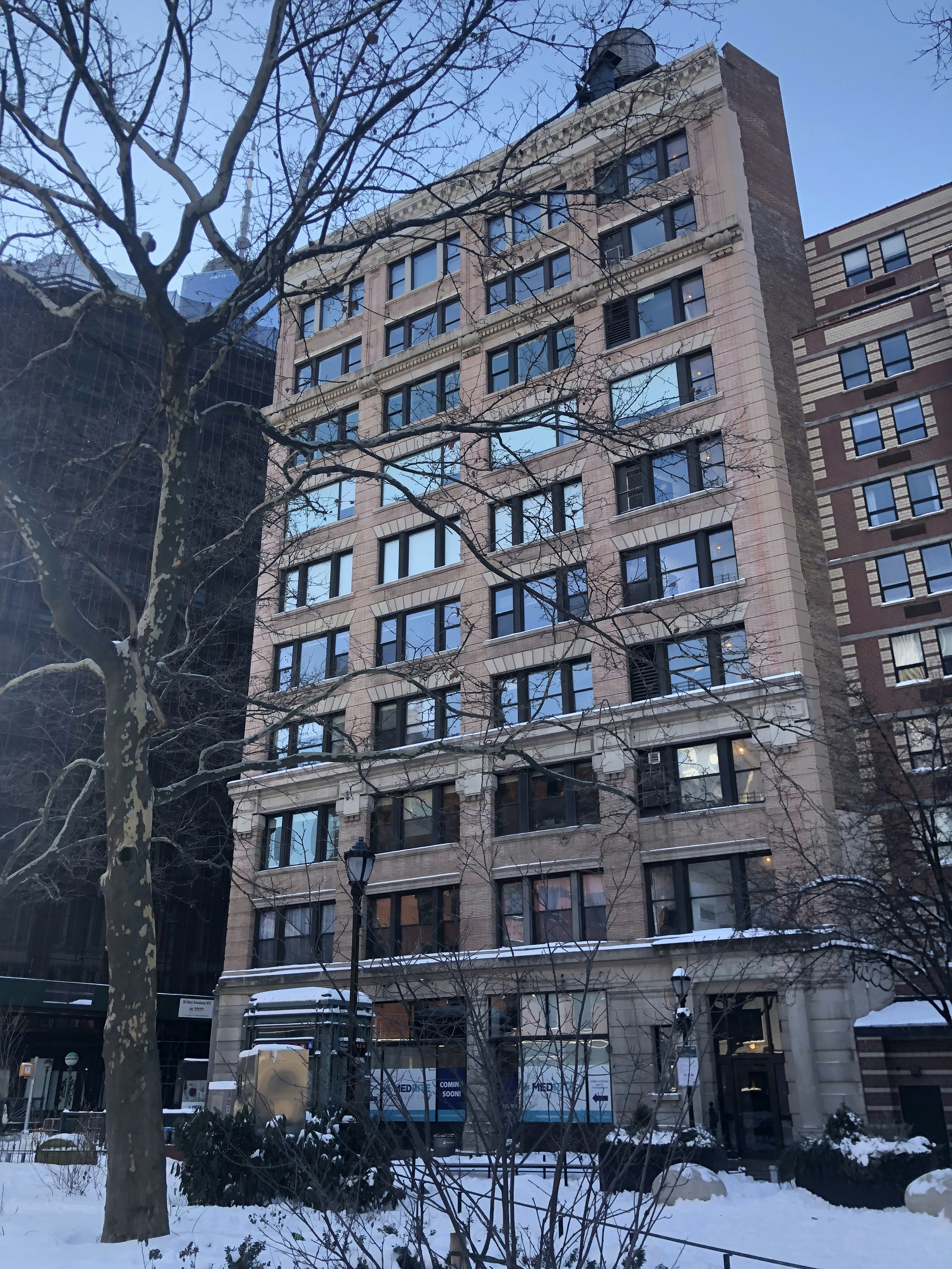 A large building with many windows and a tree in front of it photo ...