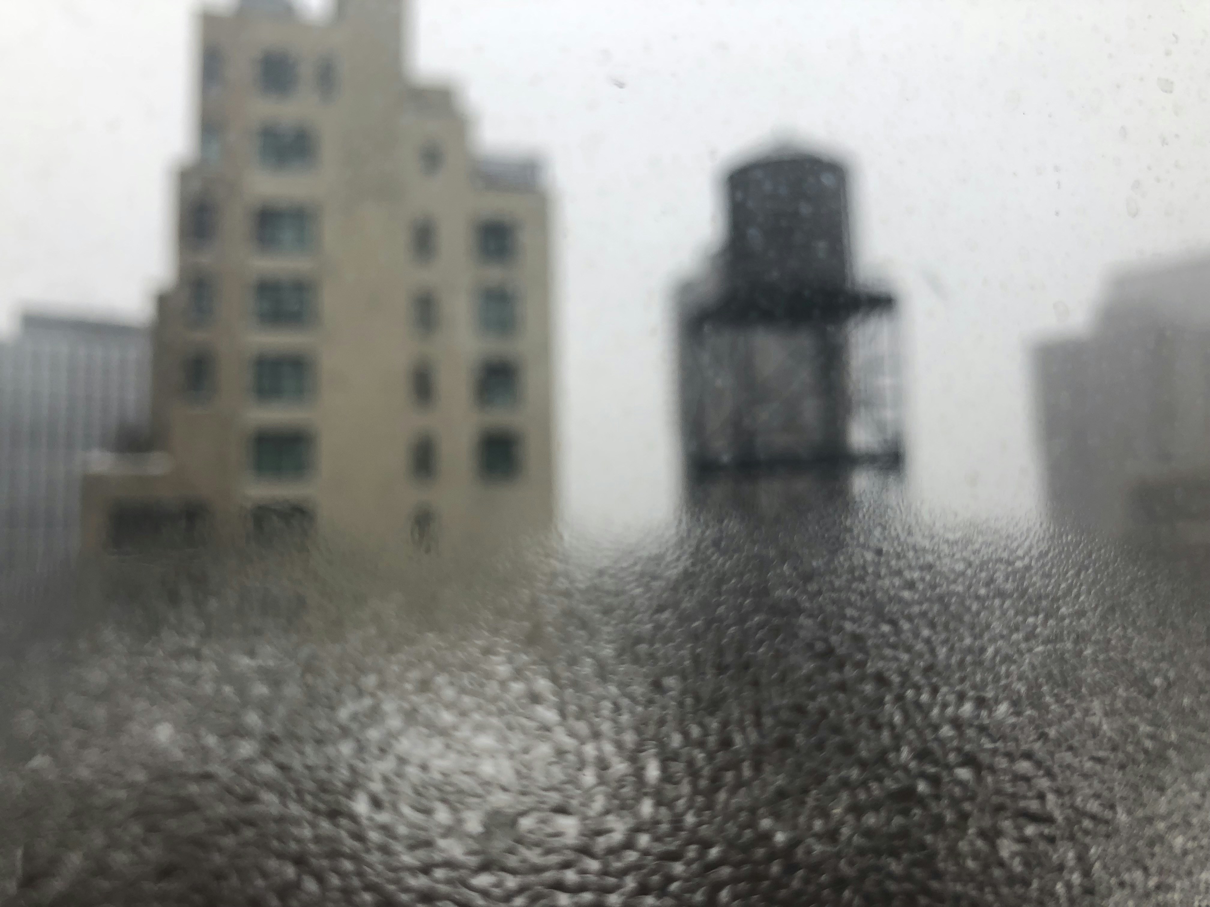 Rainscreen Reverie: A Blurred Skyline Through Wet Glass