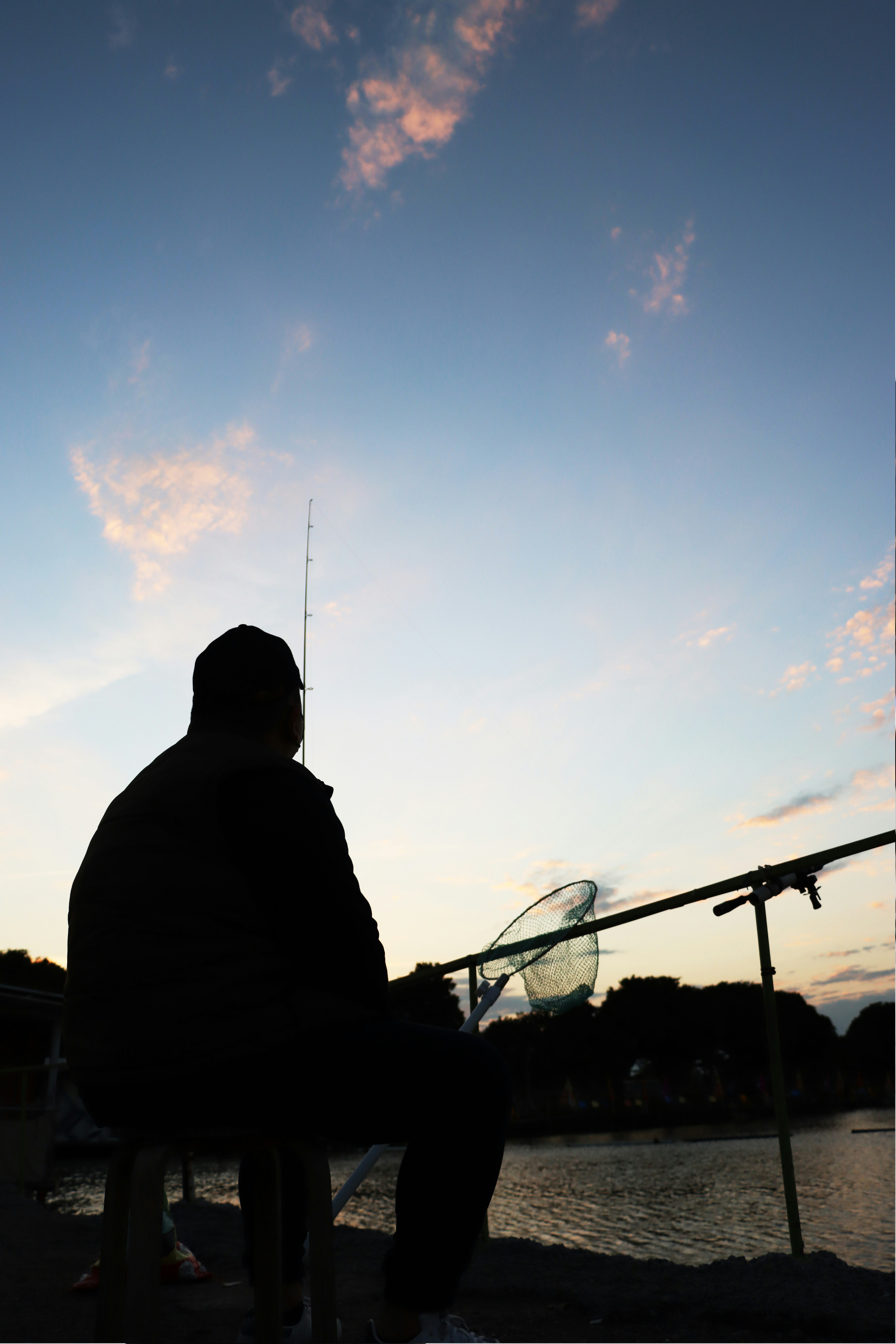 A man sitting on a bench next to a body of water photo – Free Nim wan ...