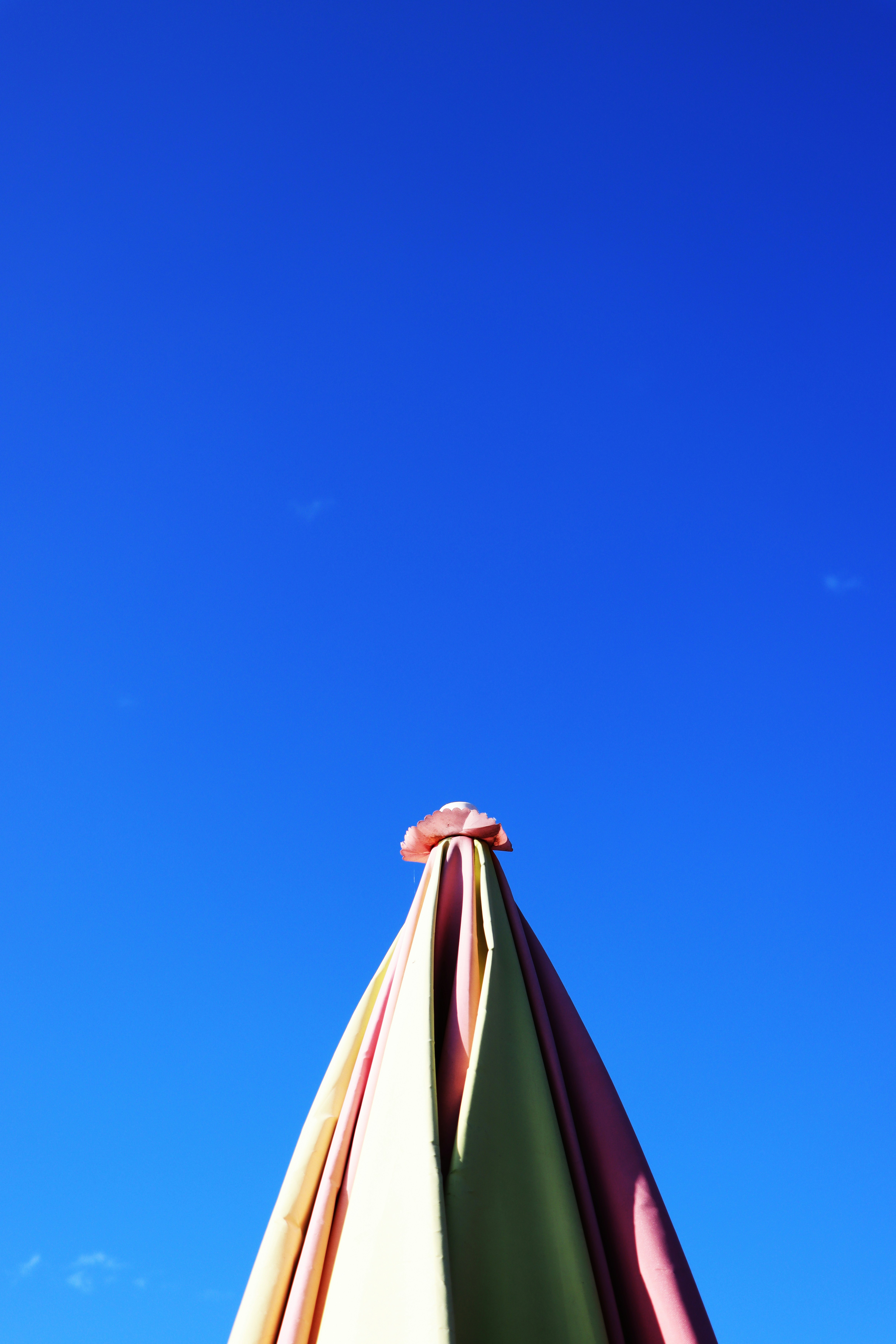 a beach umbrella with a blue sky in the background