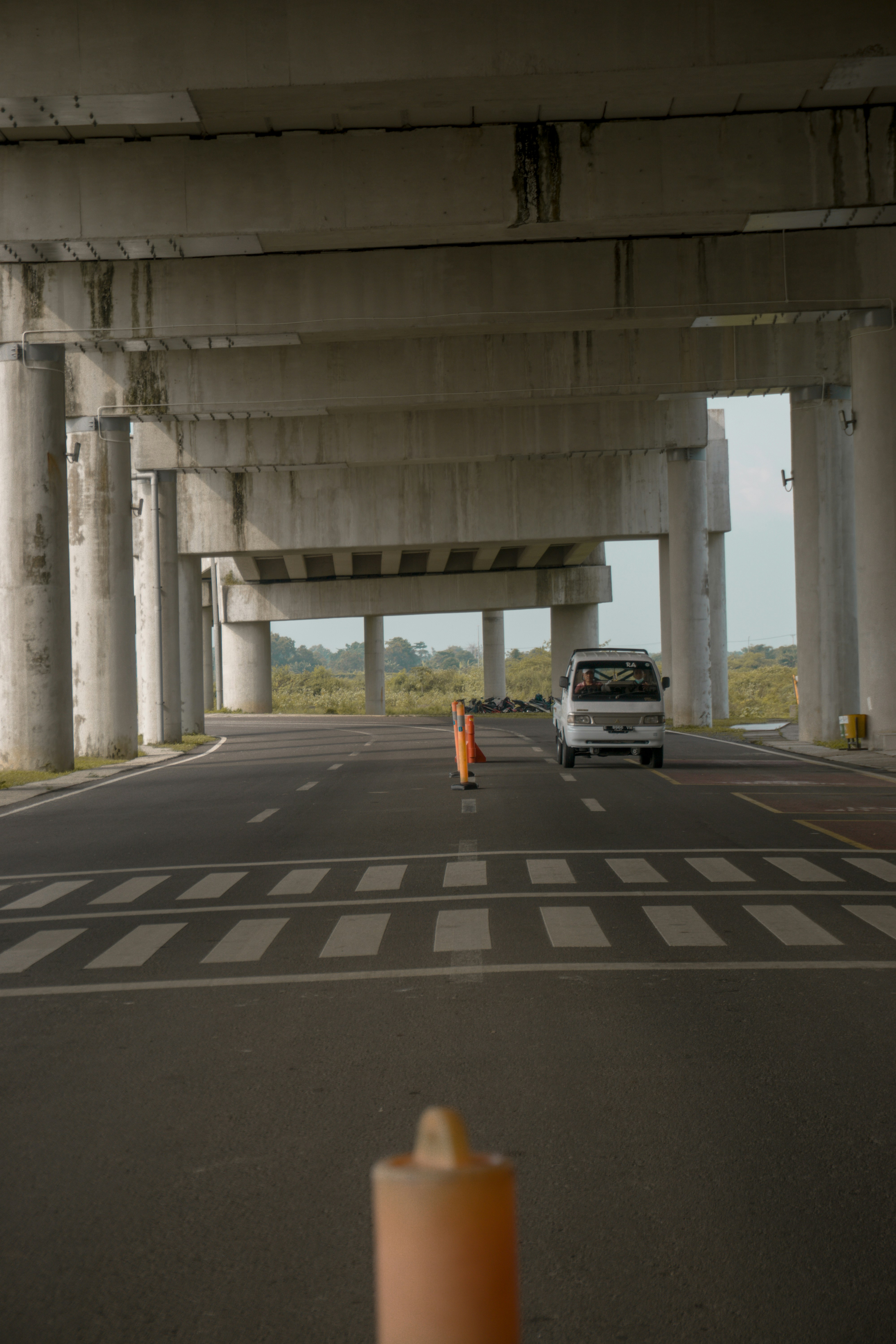 A white van driving down a street under a bridge photo – Free Road ...