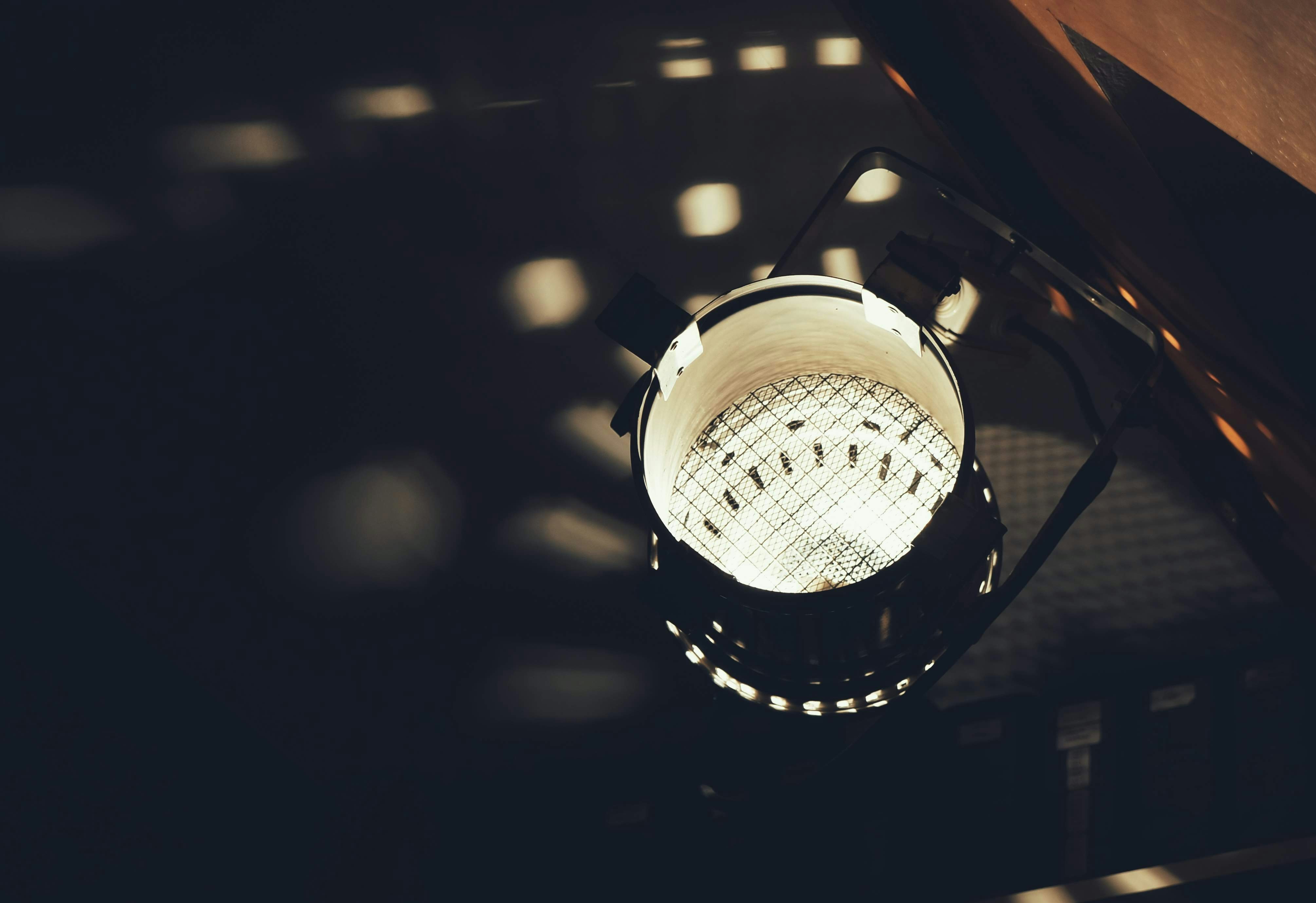 A spotlight casting intricate shadows on a surface, highlighting the interplay of illumination and darkness.