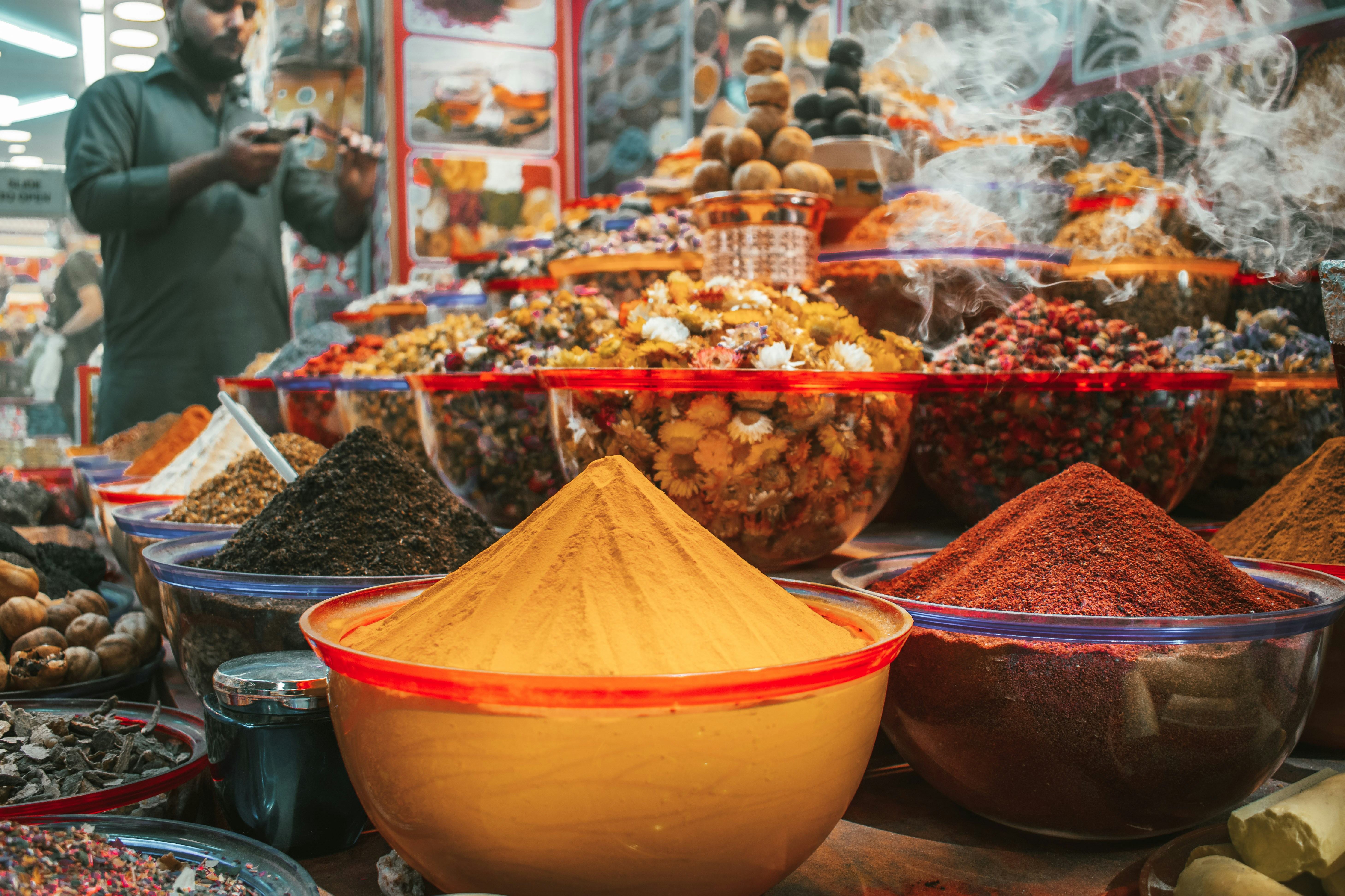 A man standing in a store filled with lots of different types of spices ...