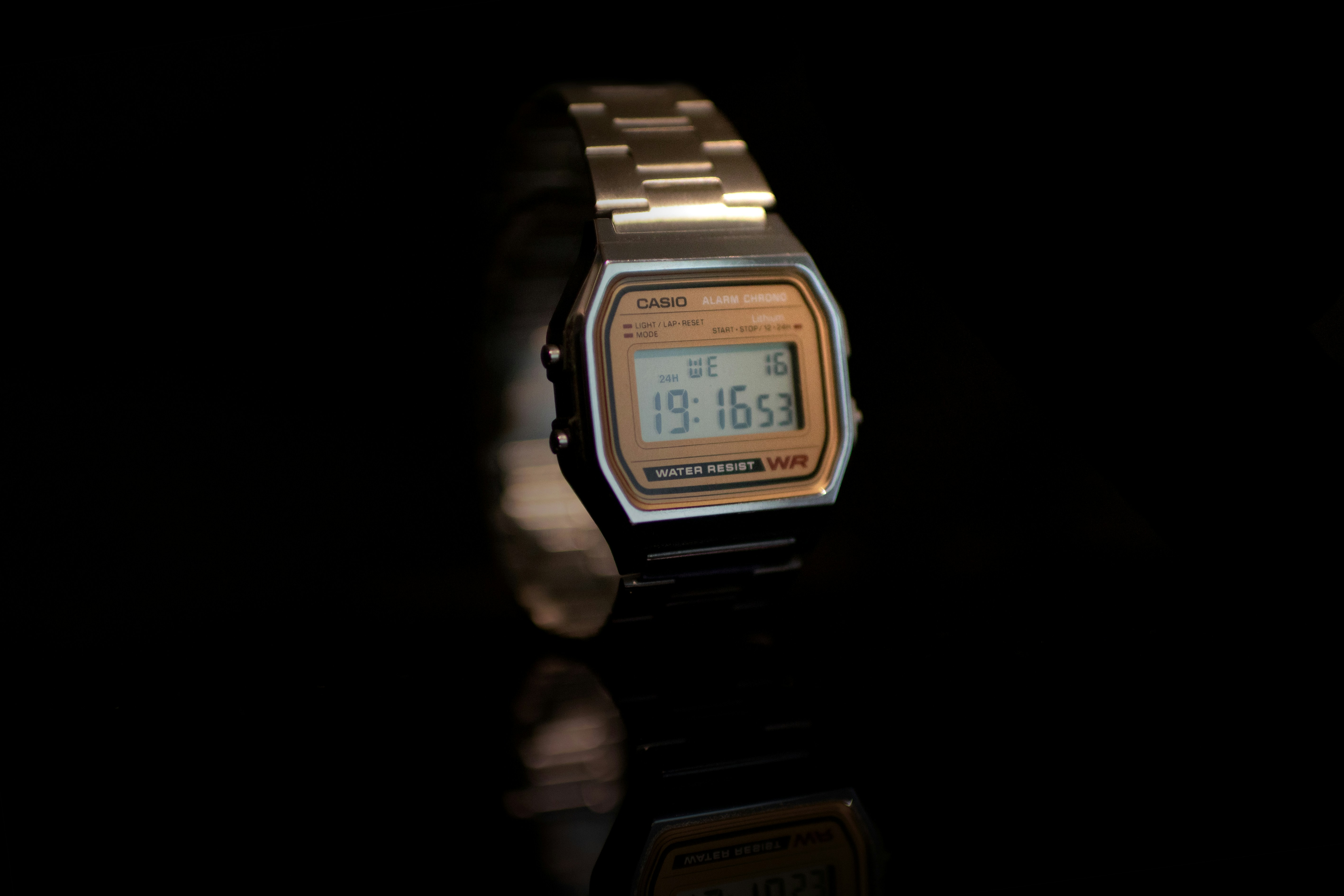 Casio digital watch displayed against a black background, showcasing its sleek design and glowing screen.