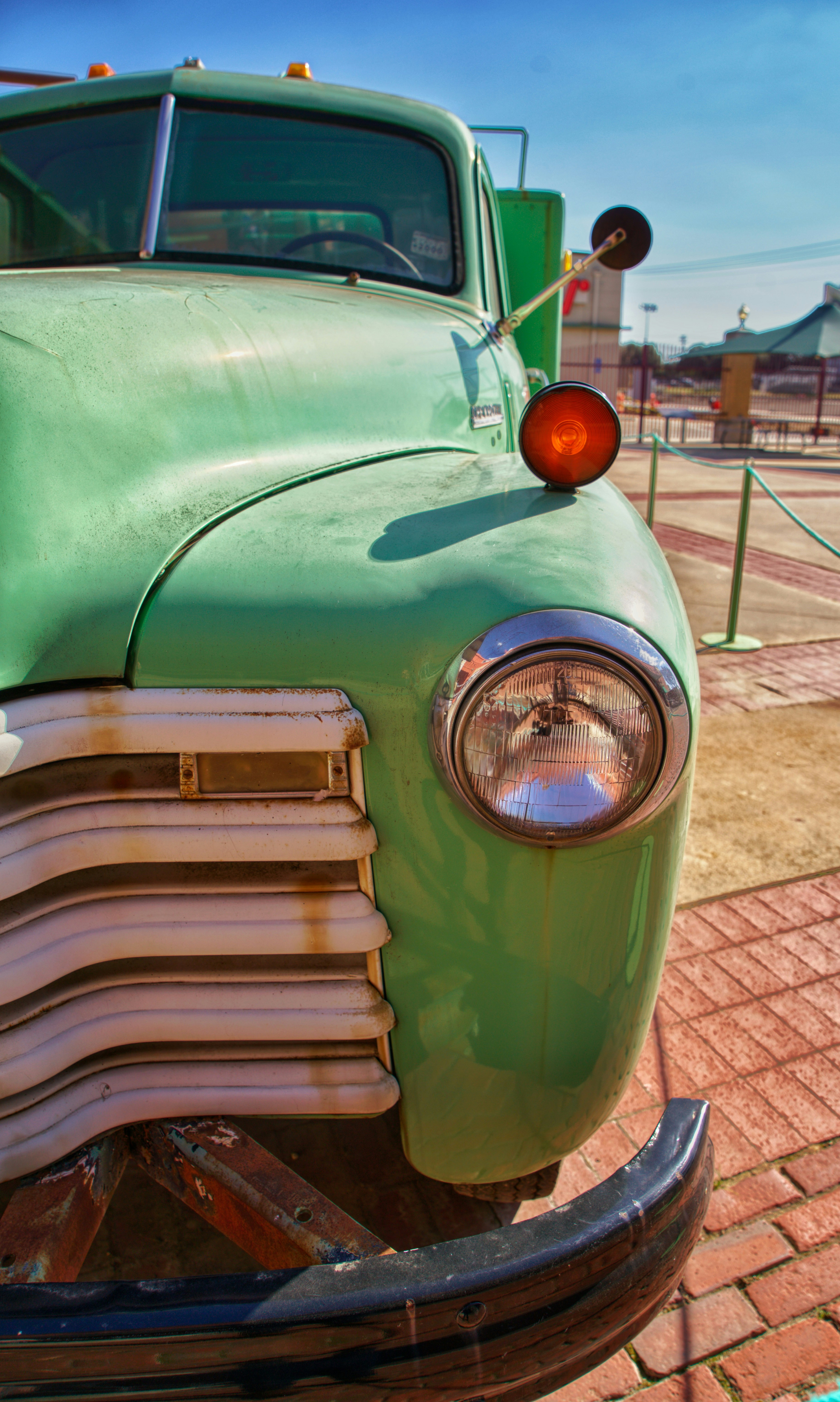 Vintage Green Pickup, Focused on the Weathered Chrome and Headlamp