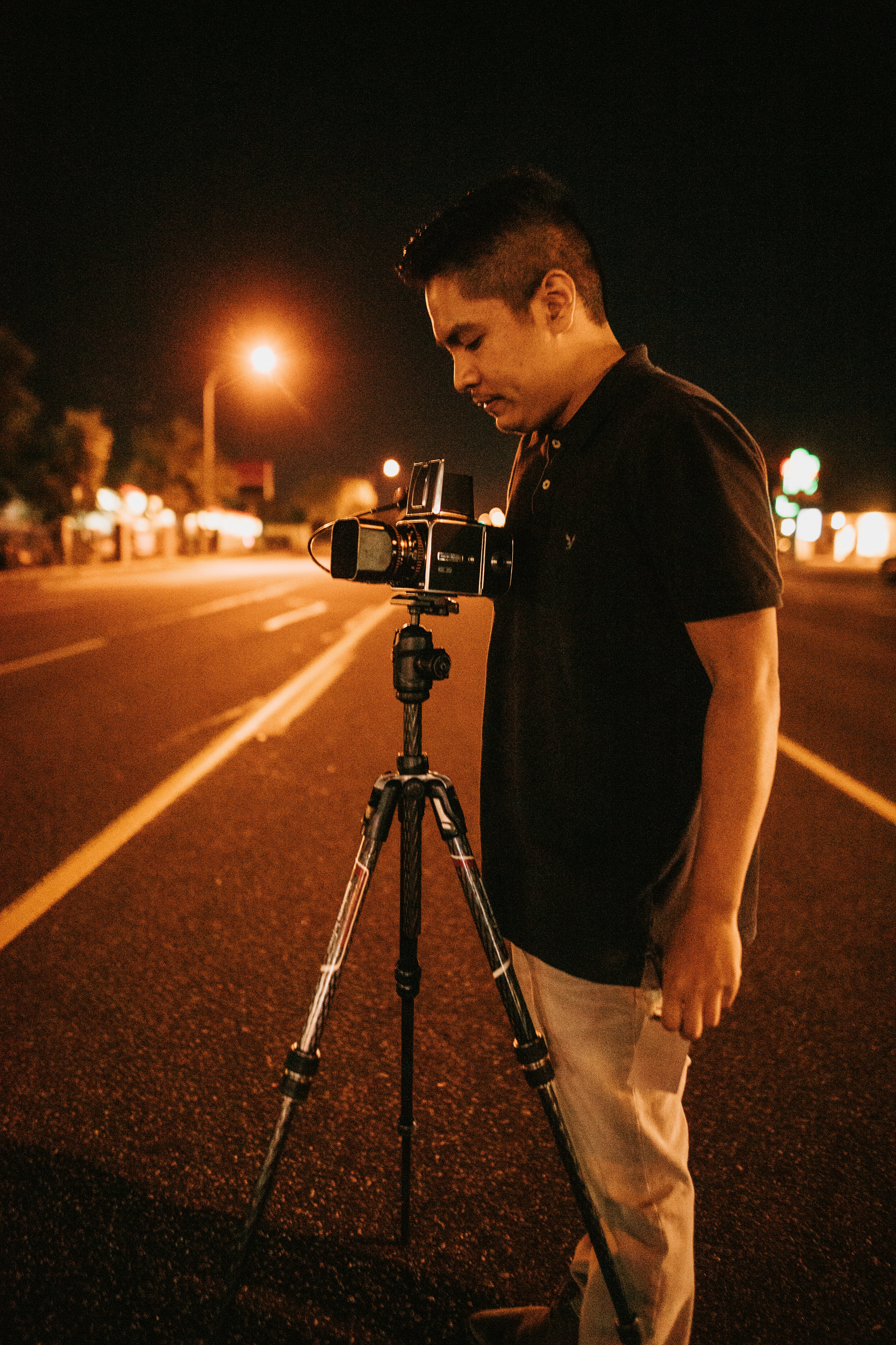 a man standing on the side of a road holding a camera