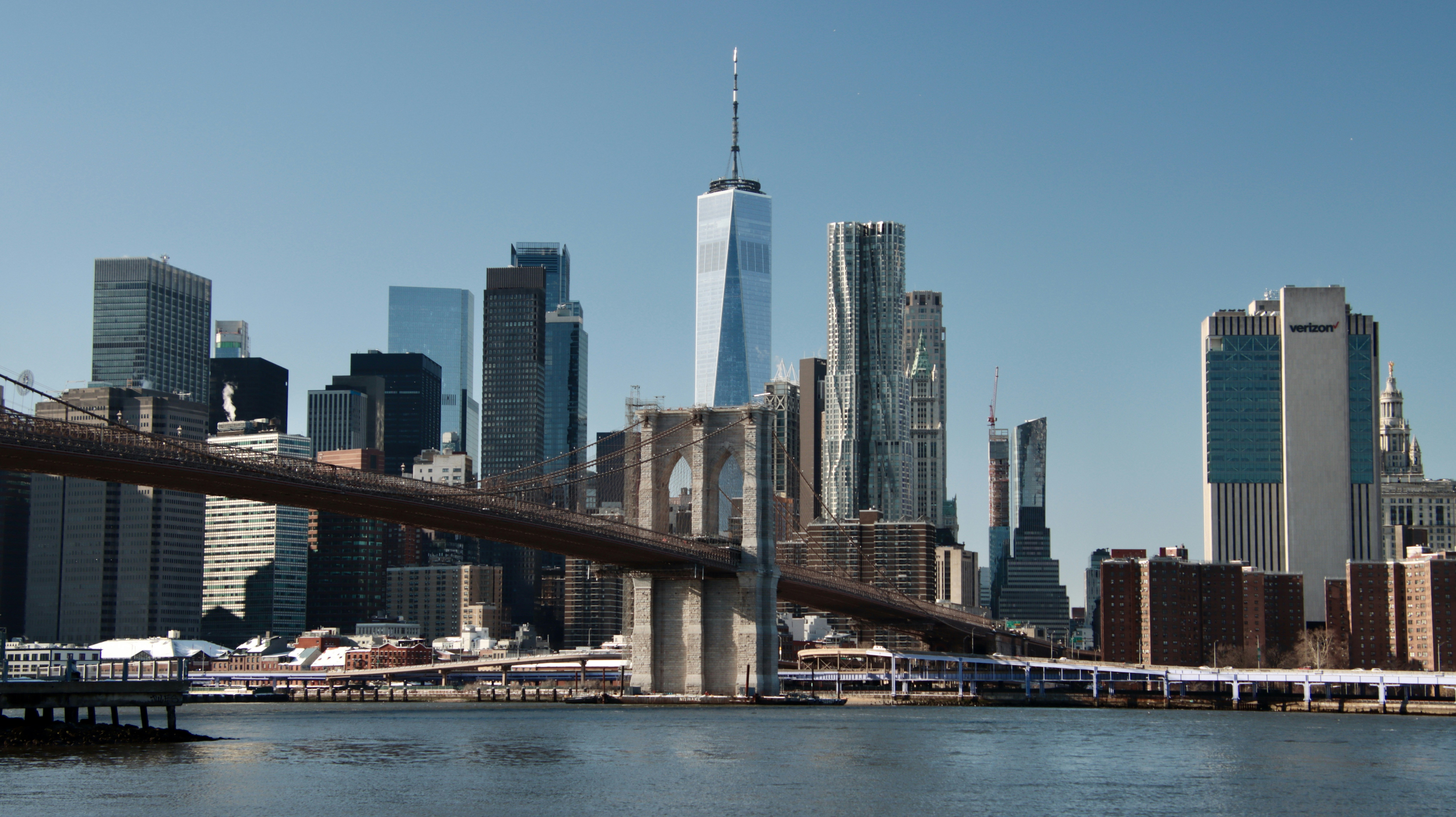 A view of a city skyline with a bridge in the foreground photo – Free ...