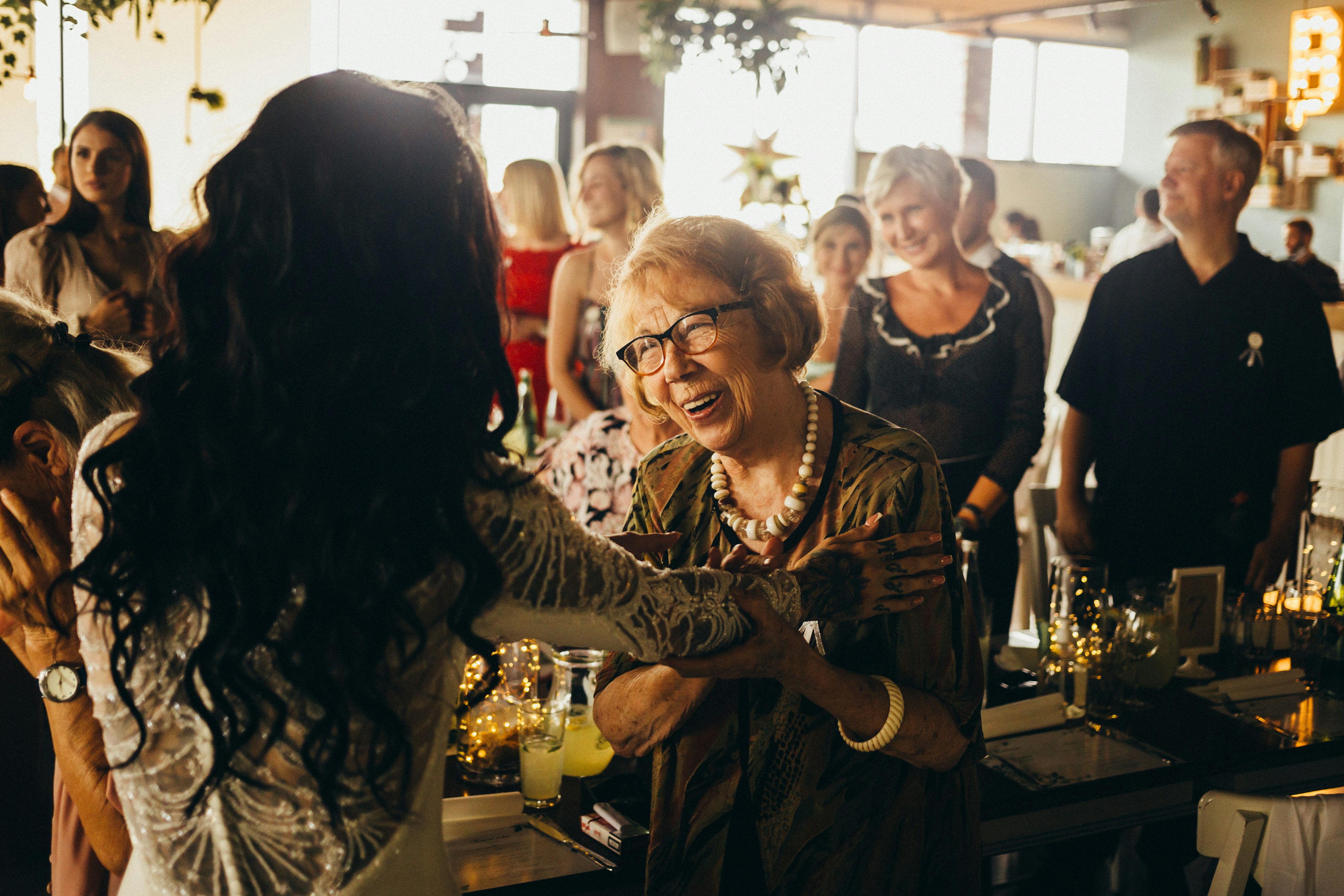 A group of people standing around a bar photo – Free Person Image on ...