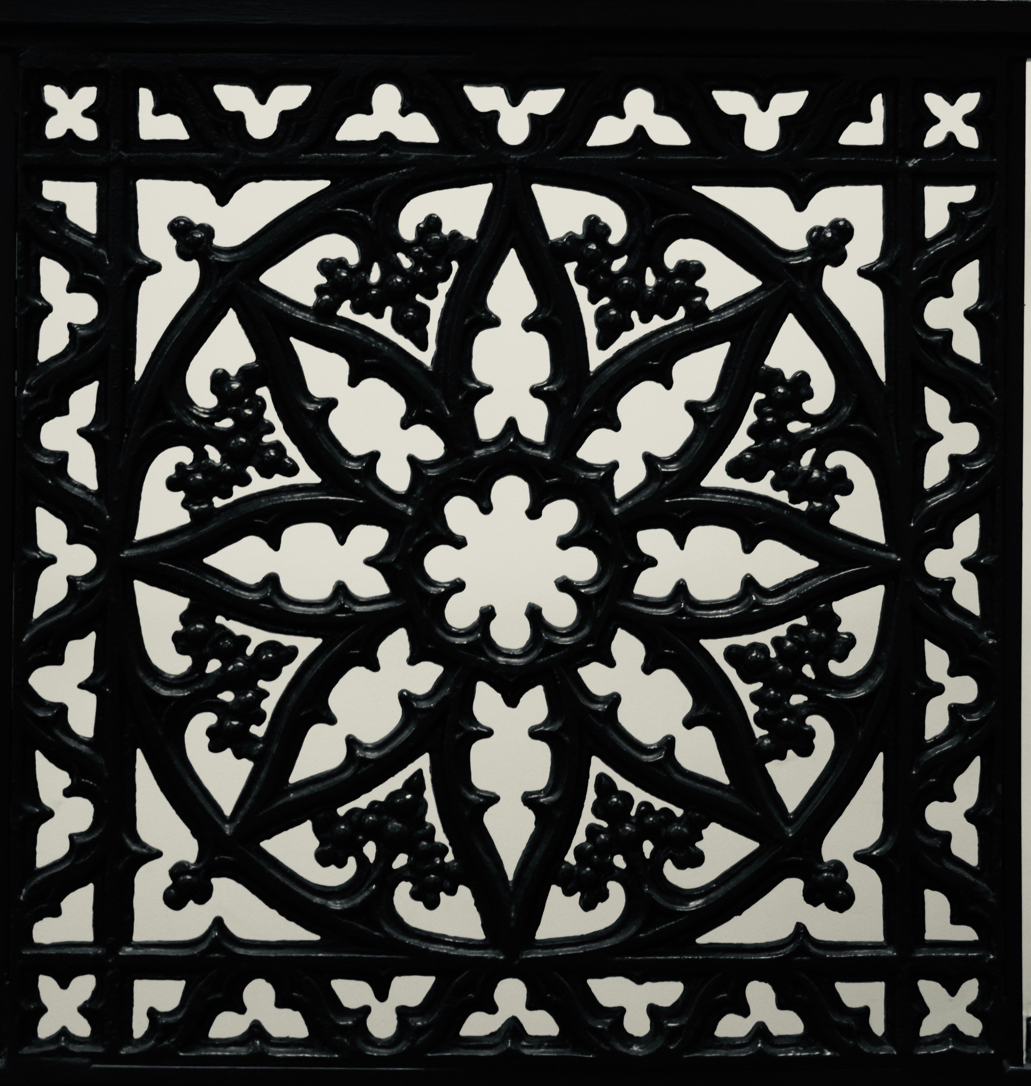 Ornate black and white design featuring a symmetrical floral motif with detailed embellishments.