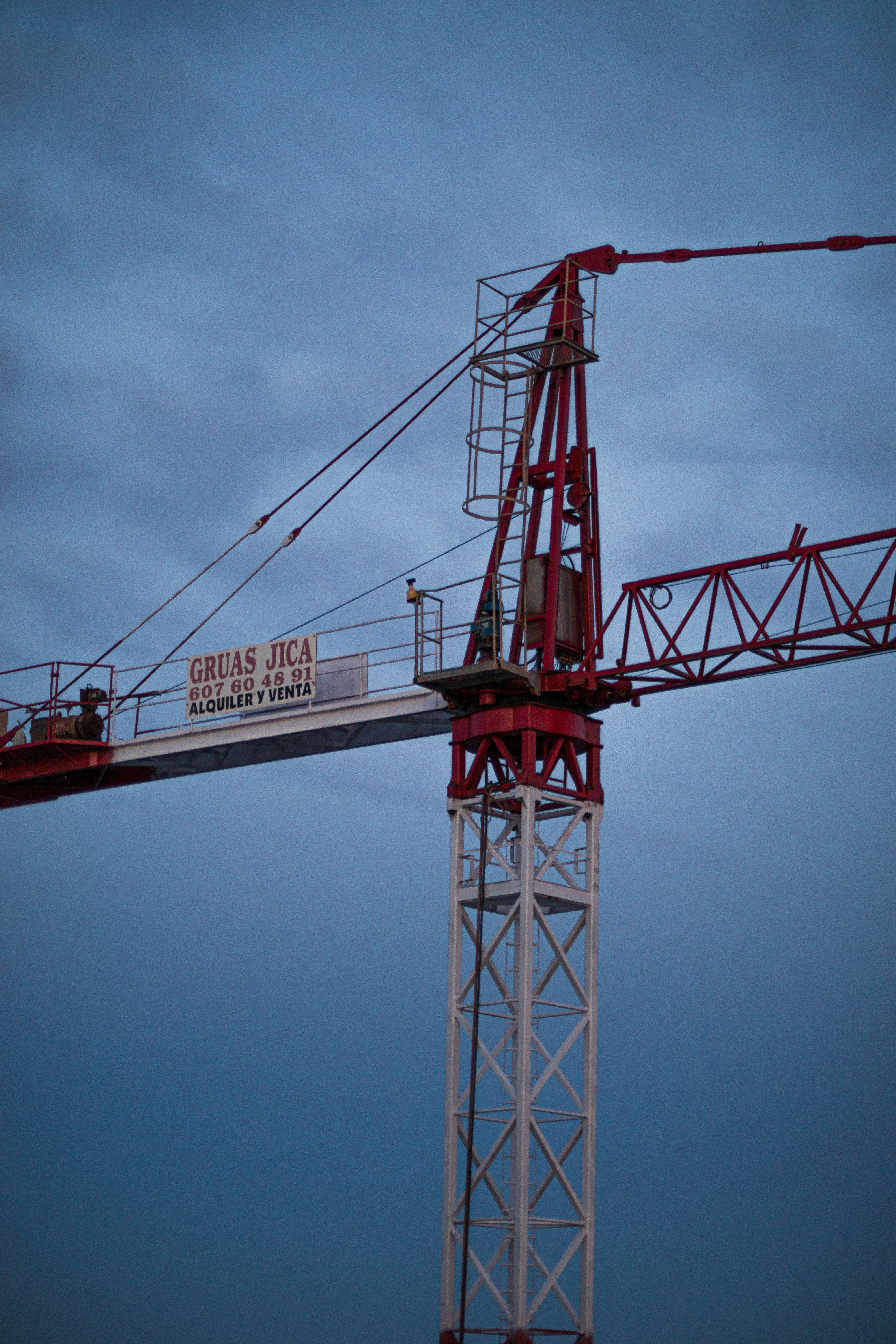 Red-lattice Crane at Dusk Over a Quiet Blue Sky