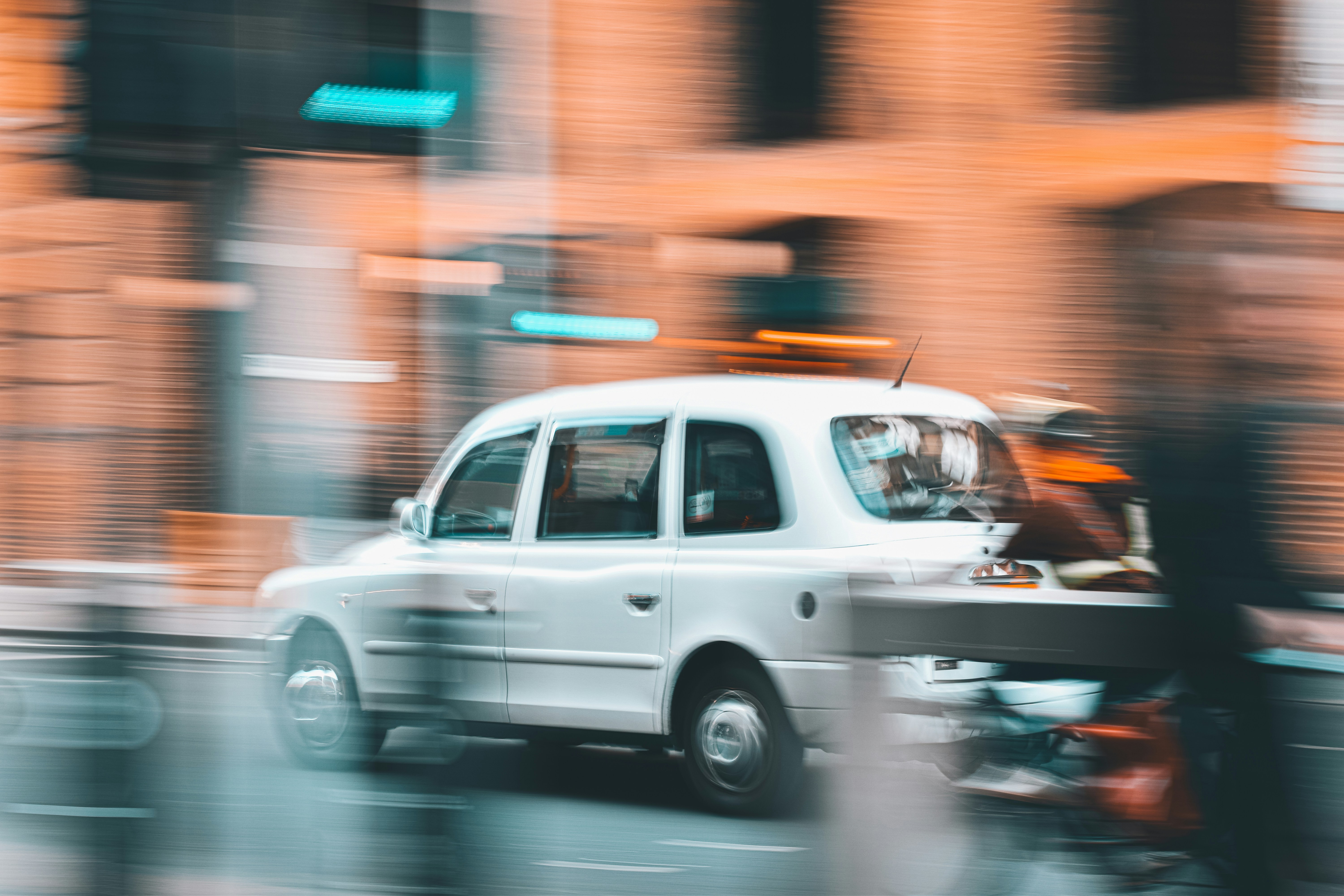 Foto Un taxi blanco conduciendo por una calle junto a edificios altos ...