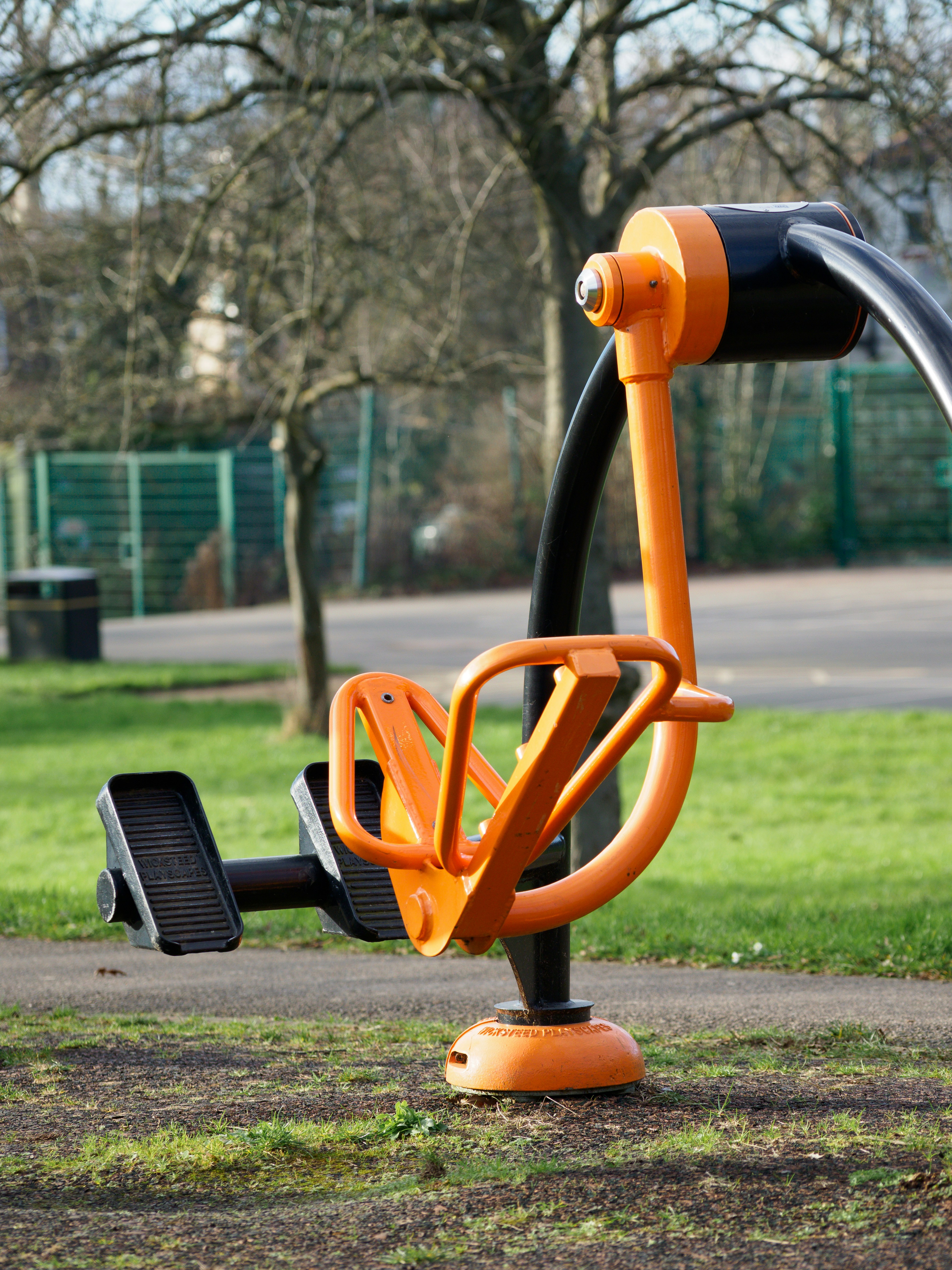 Brightly colored outdoor exercise equipment stands in a park, inviting fitness enthusiasts to engage in physical activity.
