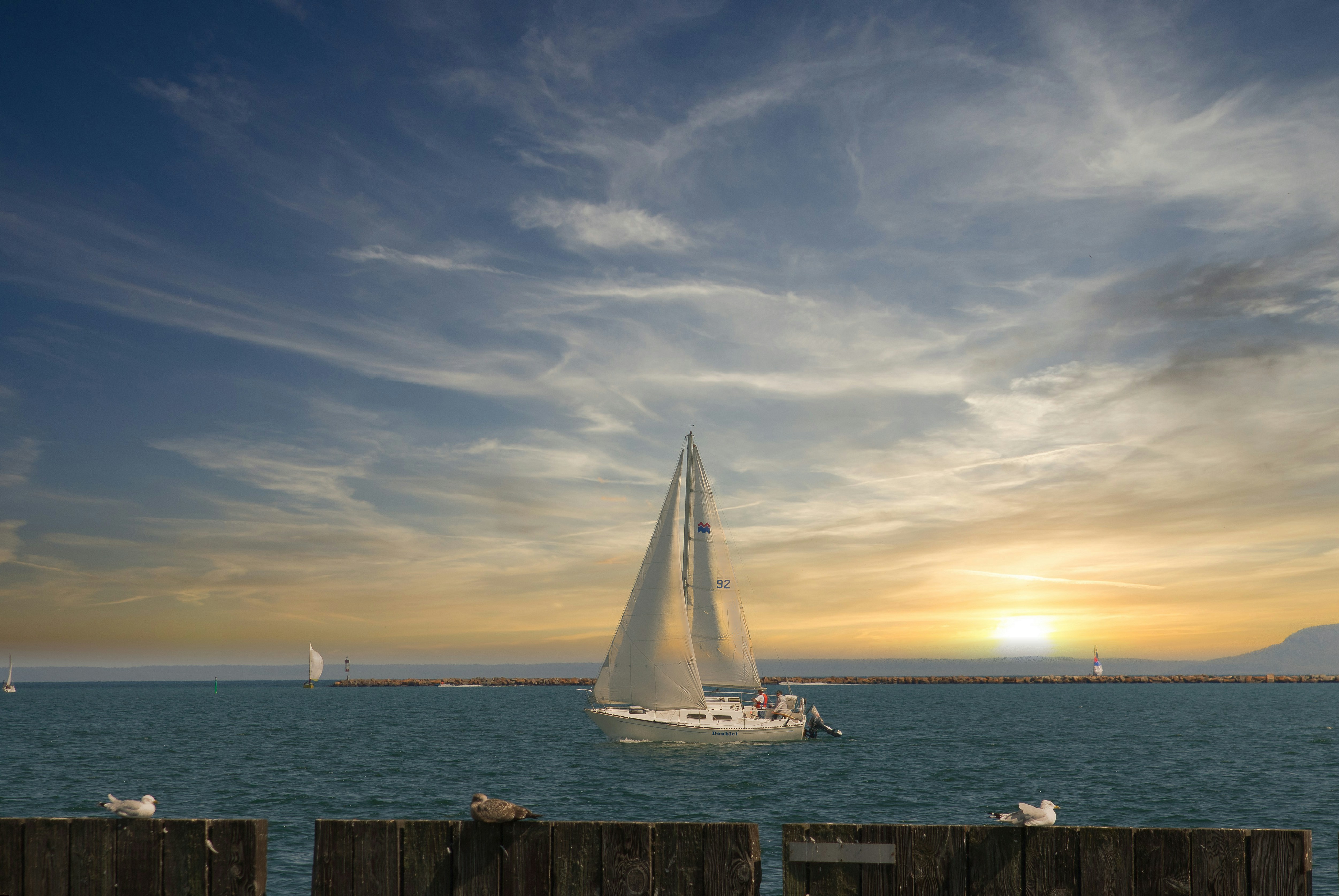 Sailboat at Dusk: A Quiet Moment Beyond the Breakwater