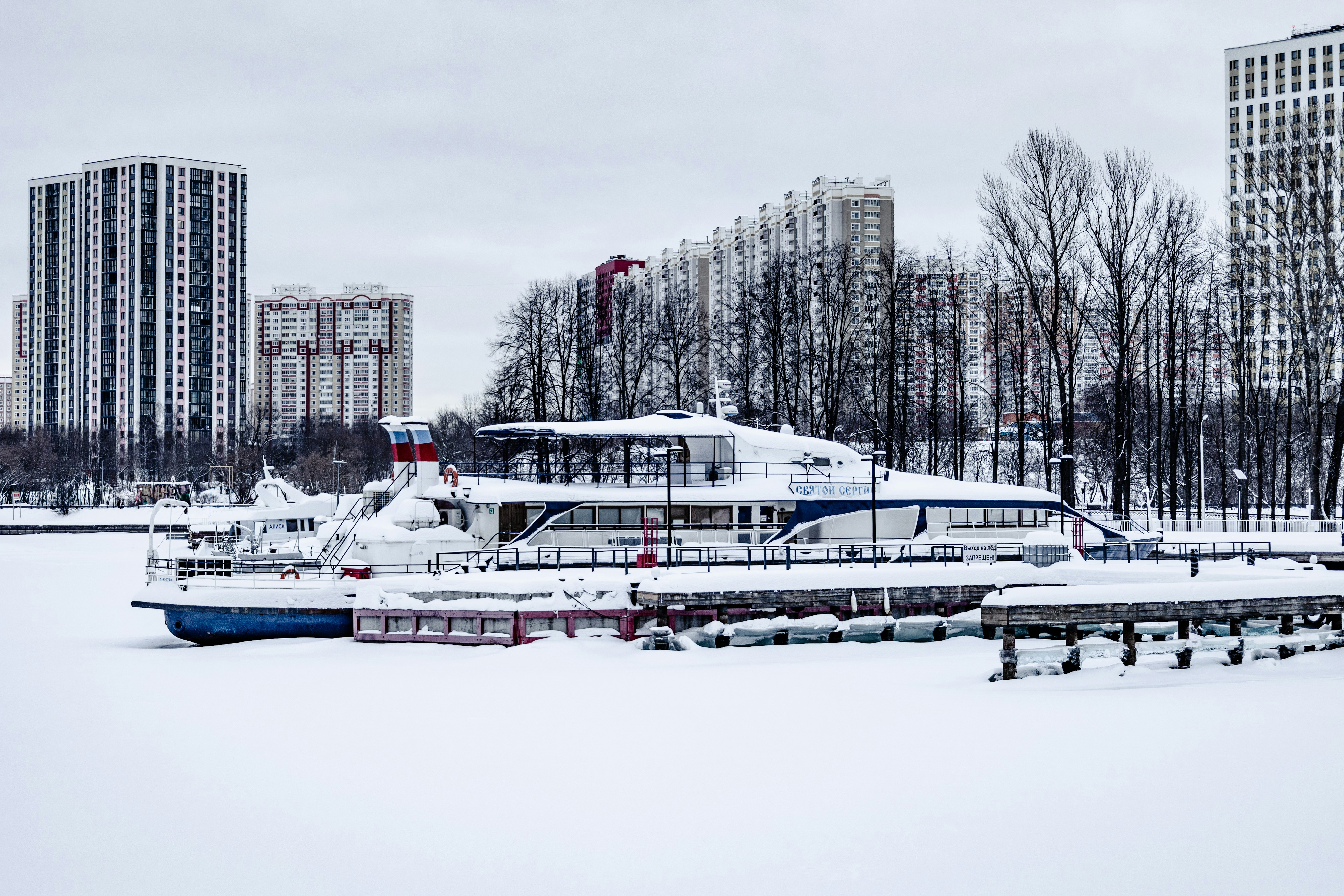 Frozen Marina Mosaic: Boats Rest Under a Stark Urban Winter Horizon