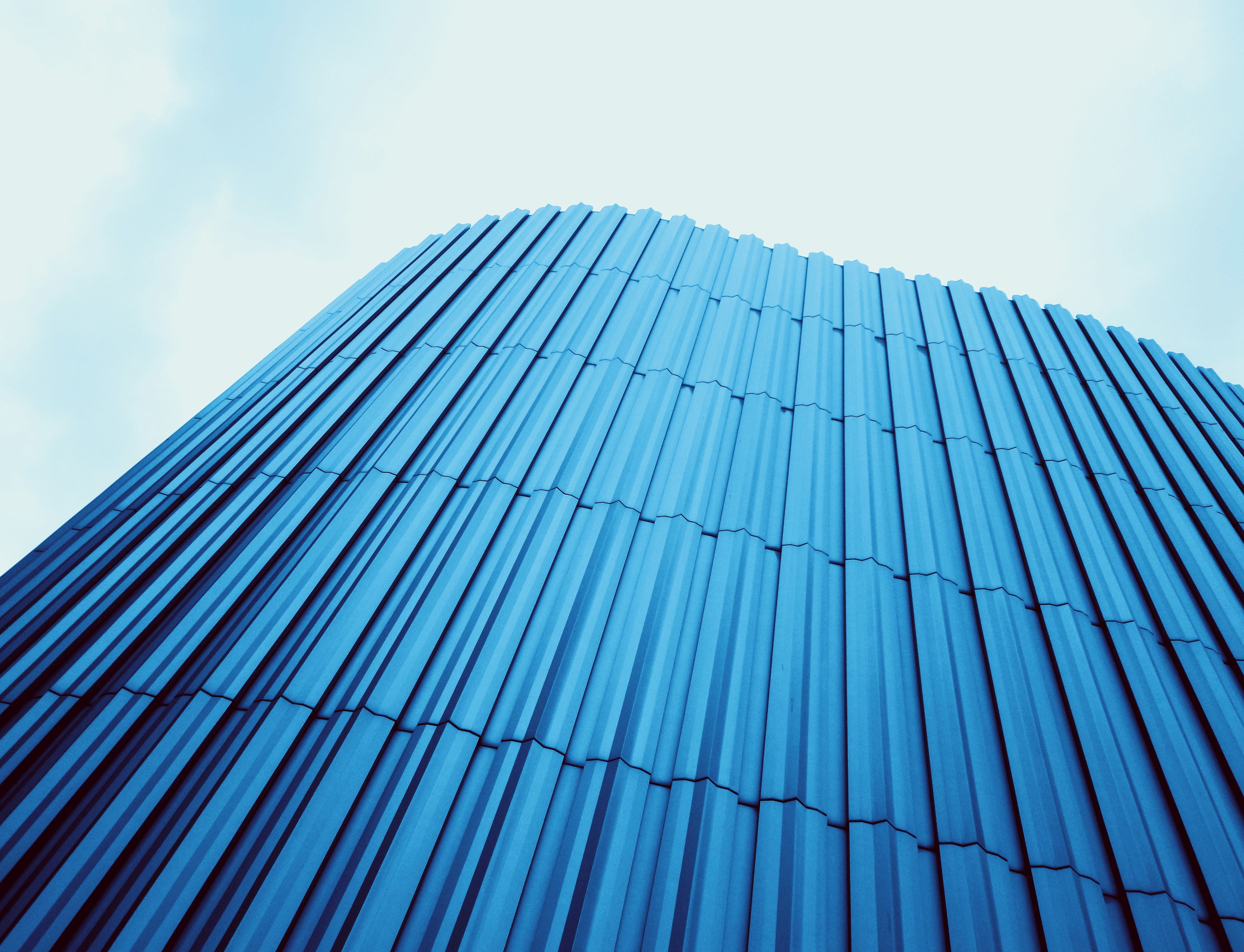 A tall blue building with a sky background photo – Free Building Image ...