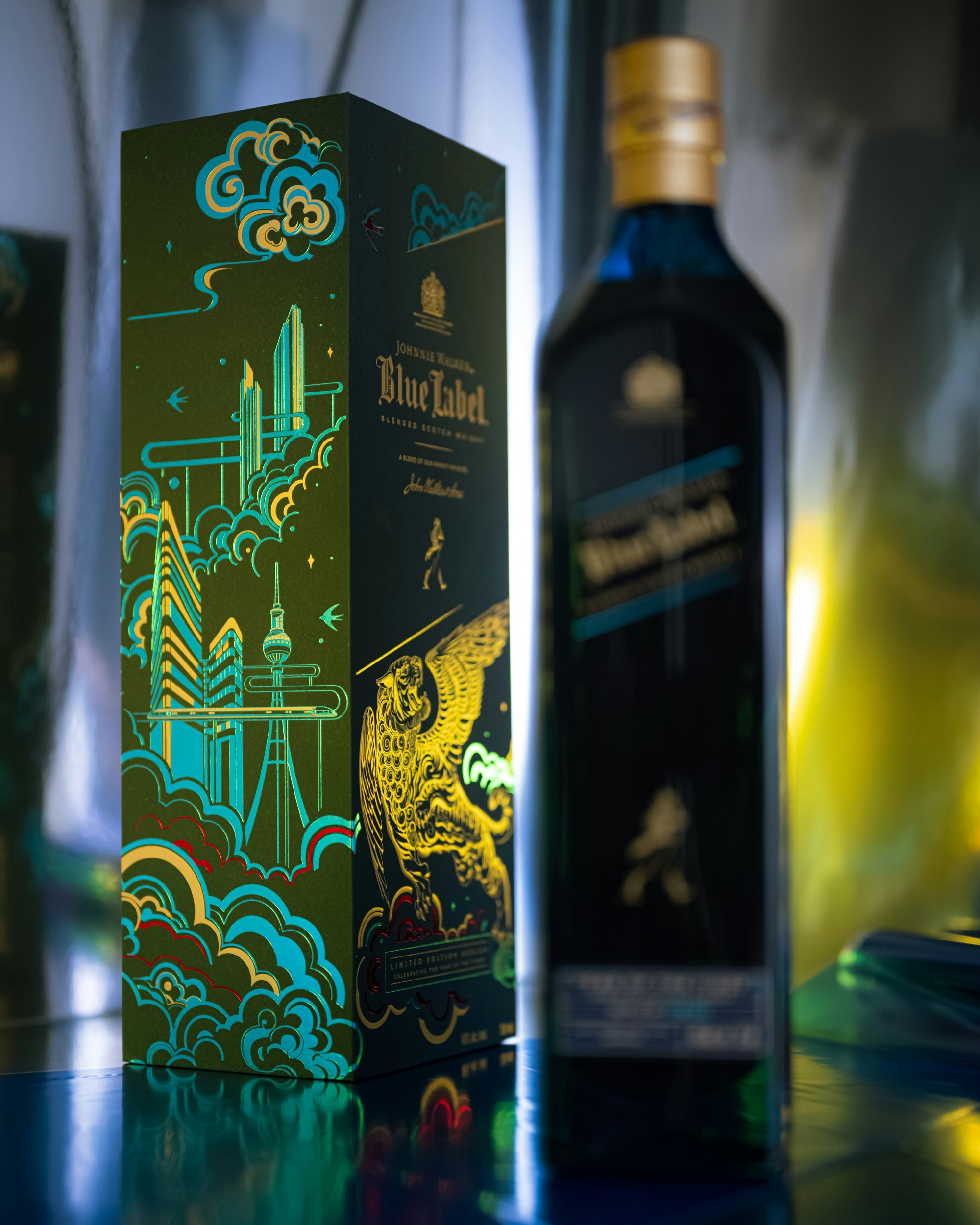 Foto Una botella de botella azul sentada junto a una caja – Imagen ...