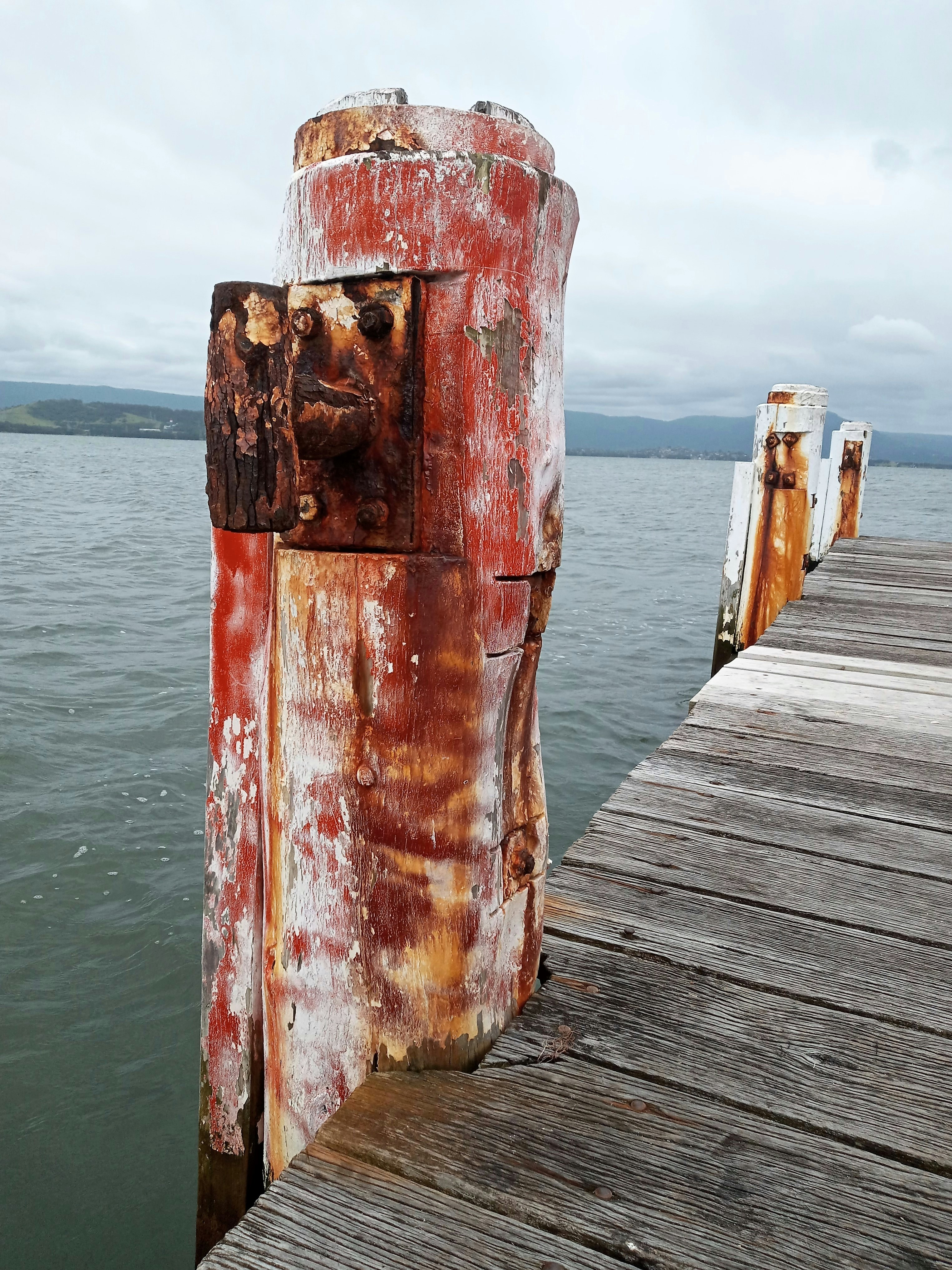 a rusted wooden dock with water in the background
