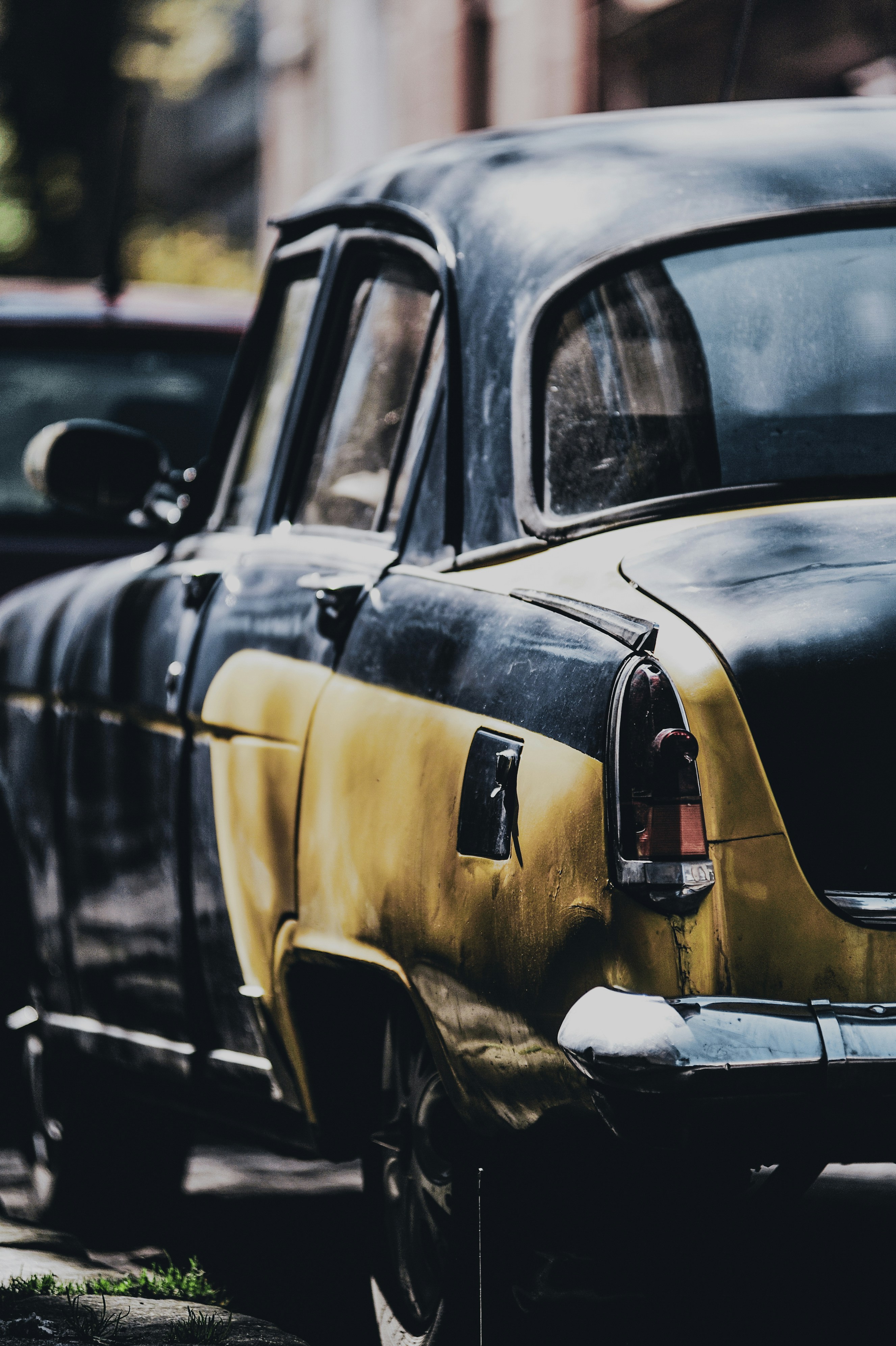 A black and yellow car parked on the side of the road photo – Free ...