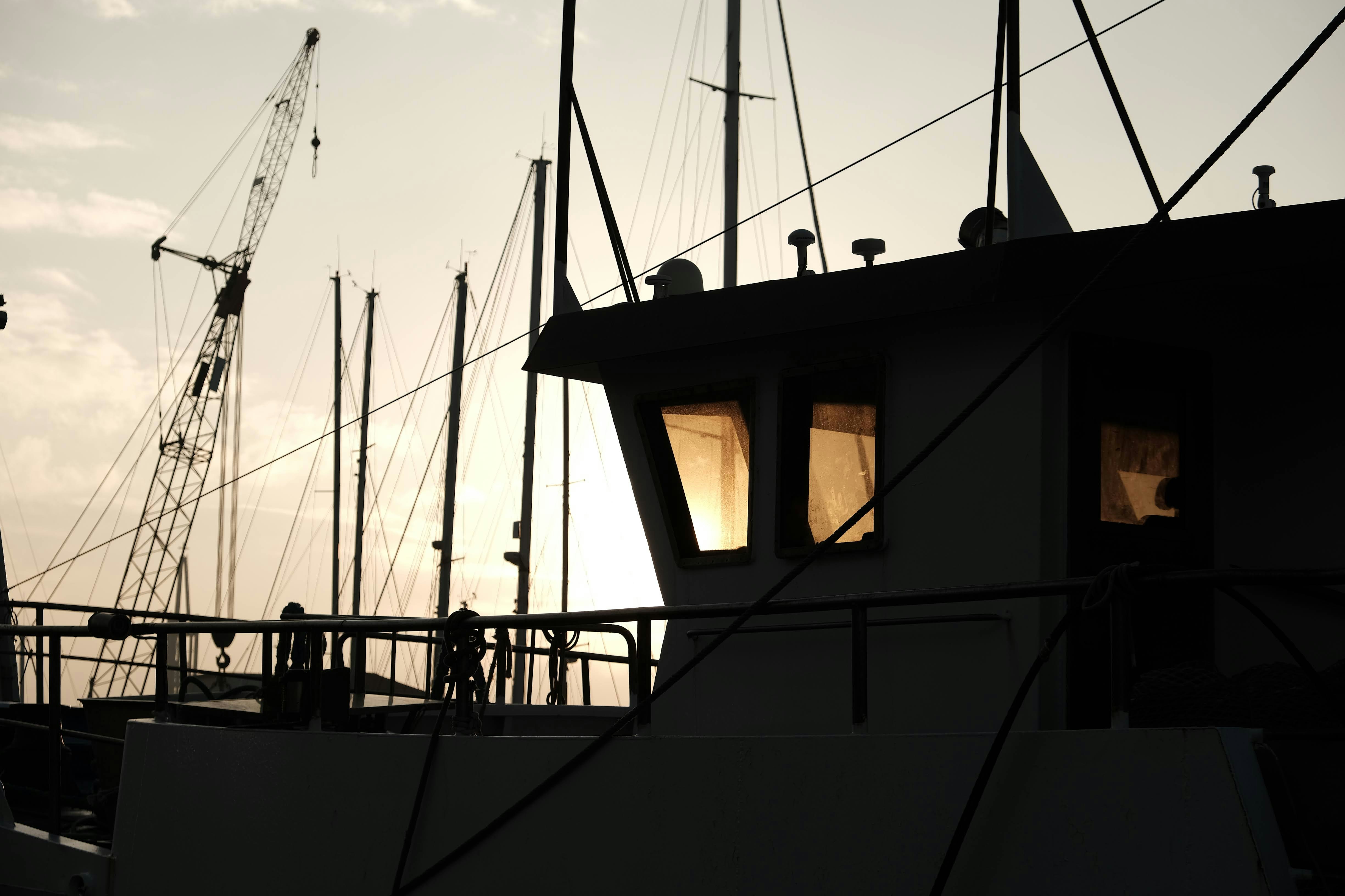 Dusk at the Dock: Lighted Cabin Amid Rigging Shadows