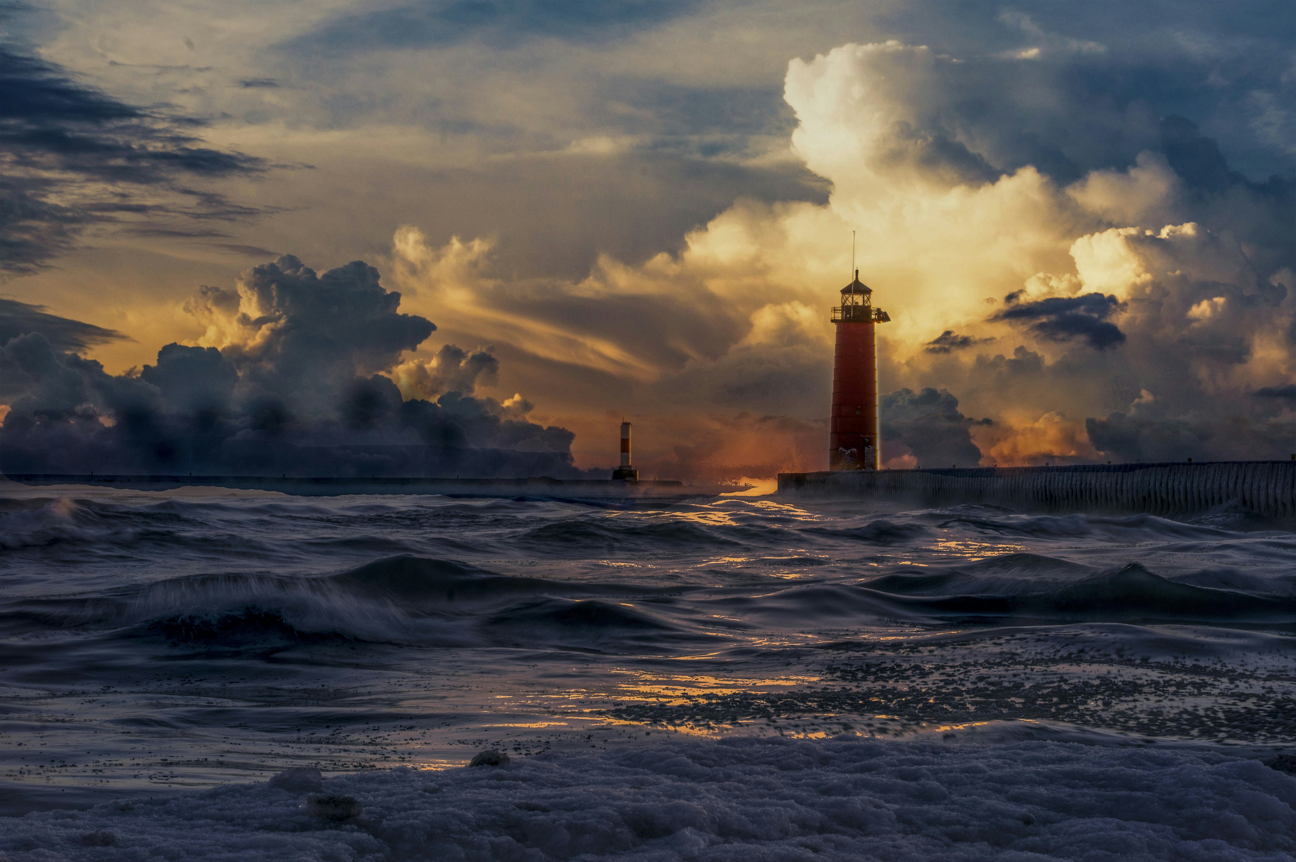 Lighthouse at Dusk: Ember Skies Over Roaring Waves