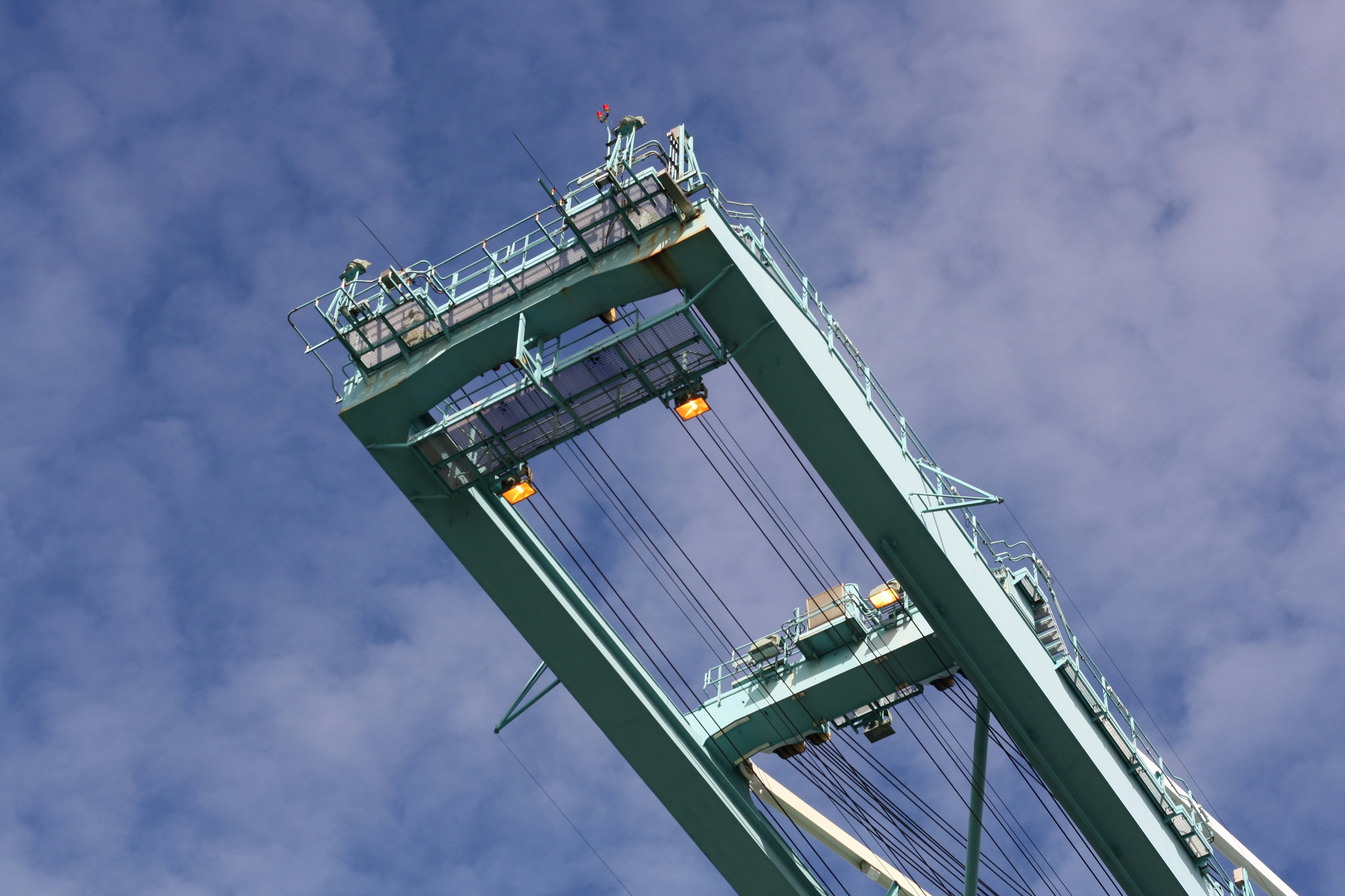A towering crane against a backdrop of blue sky, showcasing intricate structural details and vibrant colors.