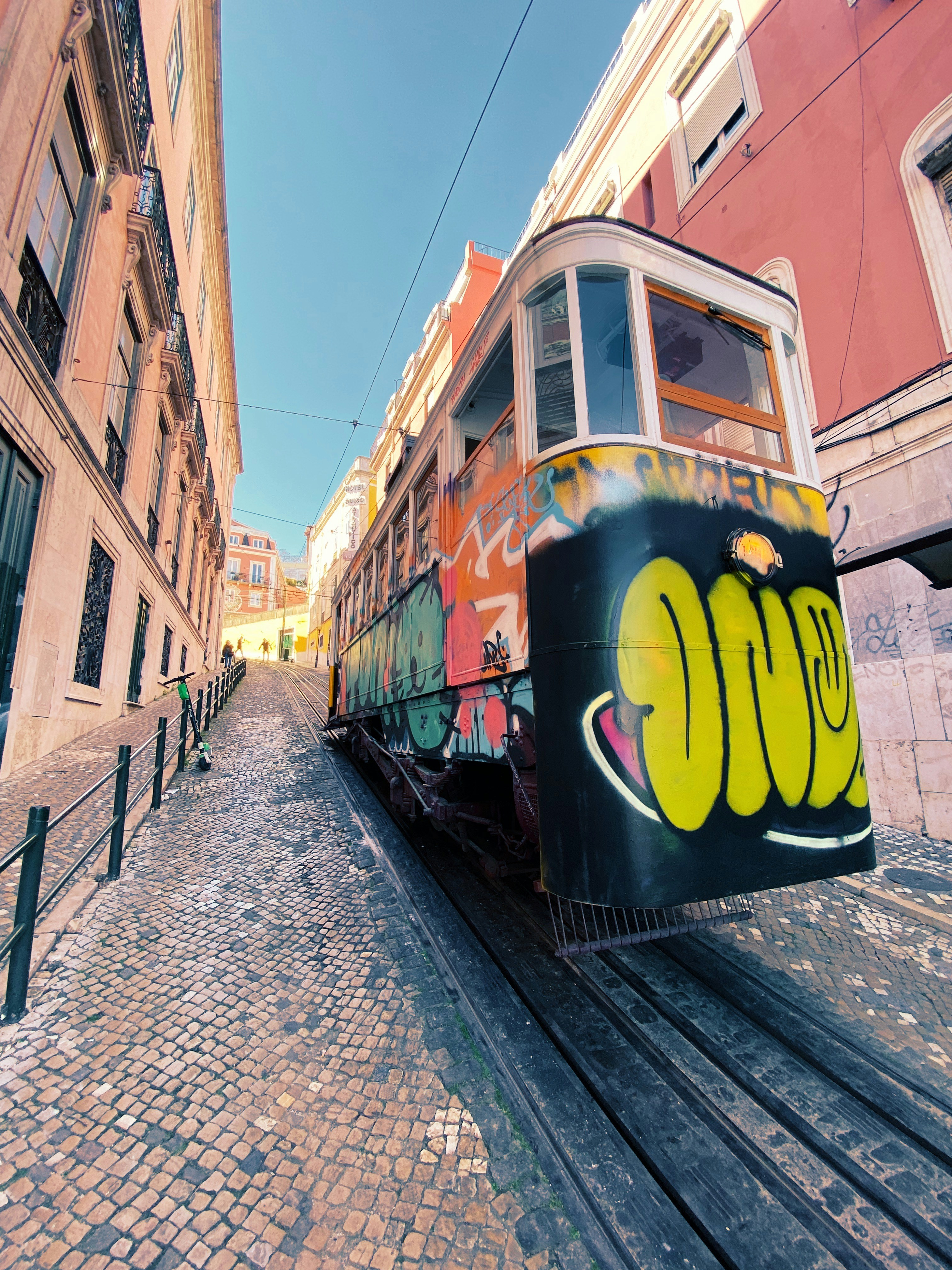 A trolley car with graffiti on the side of a street photo – Free Tram ...