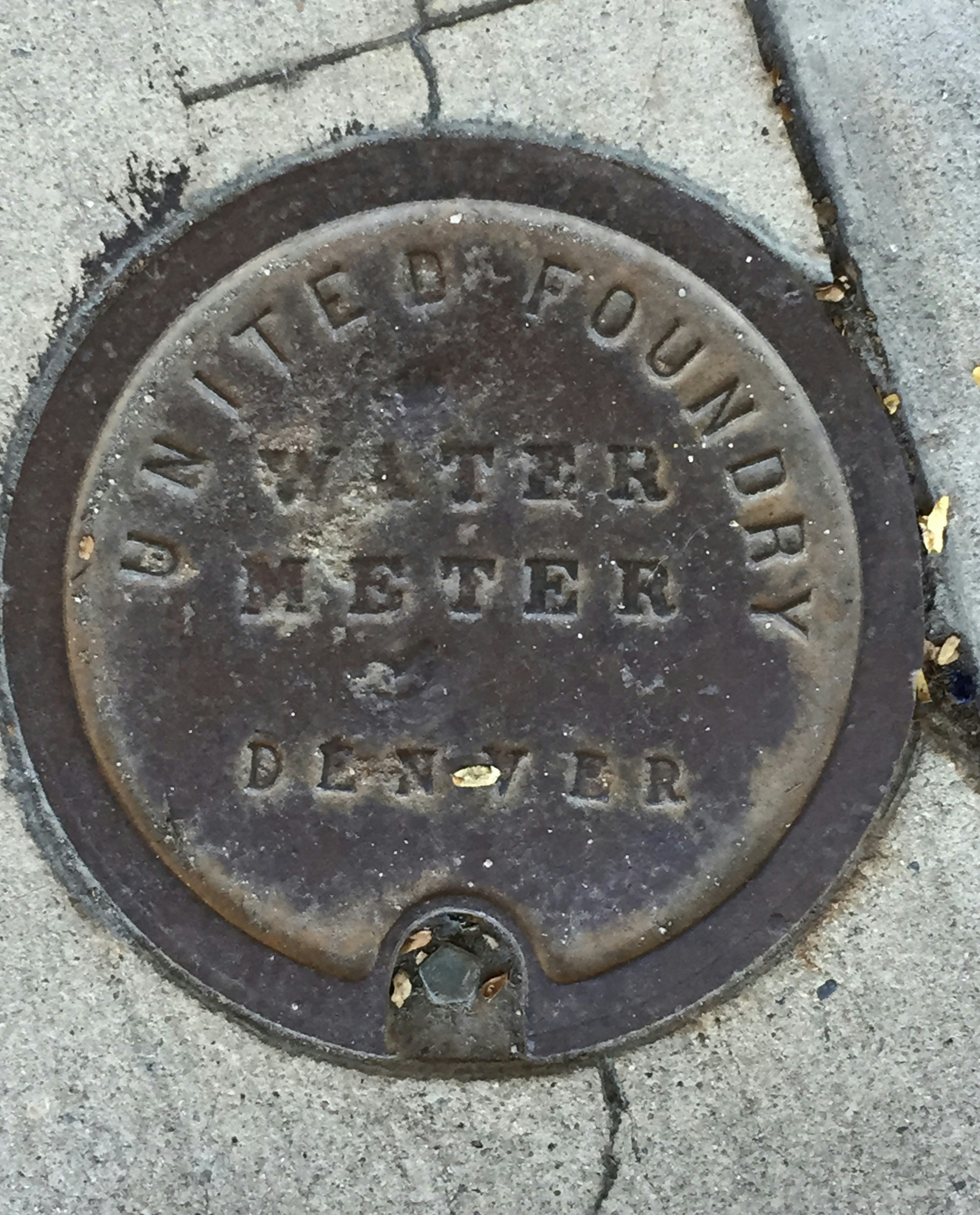 A manhole cover on the side of a sidewalk photo – Free Sewer Image on ...