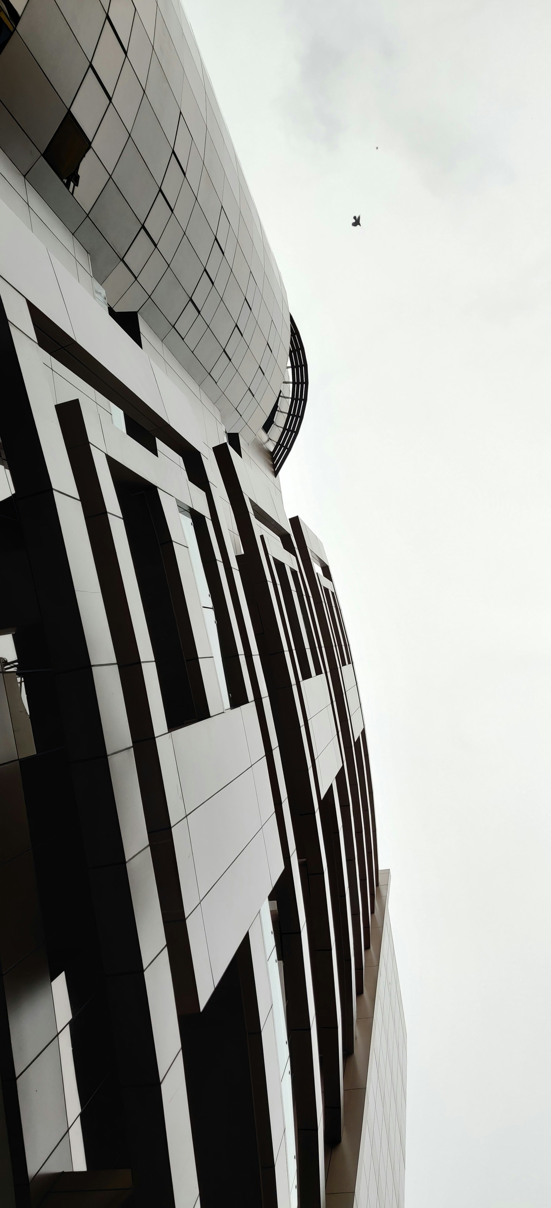 a plane flying in the sky over a building