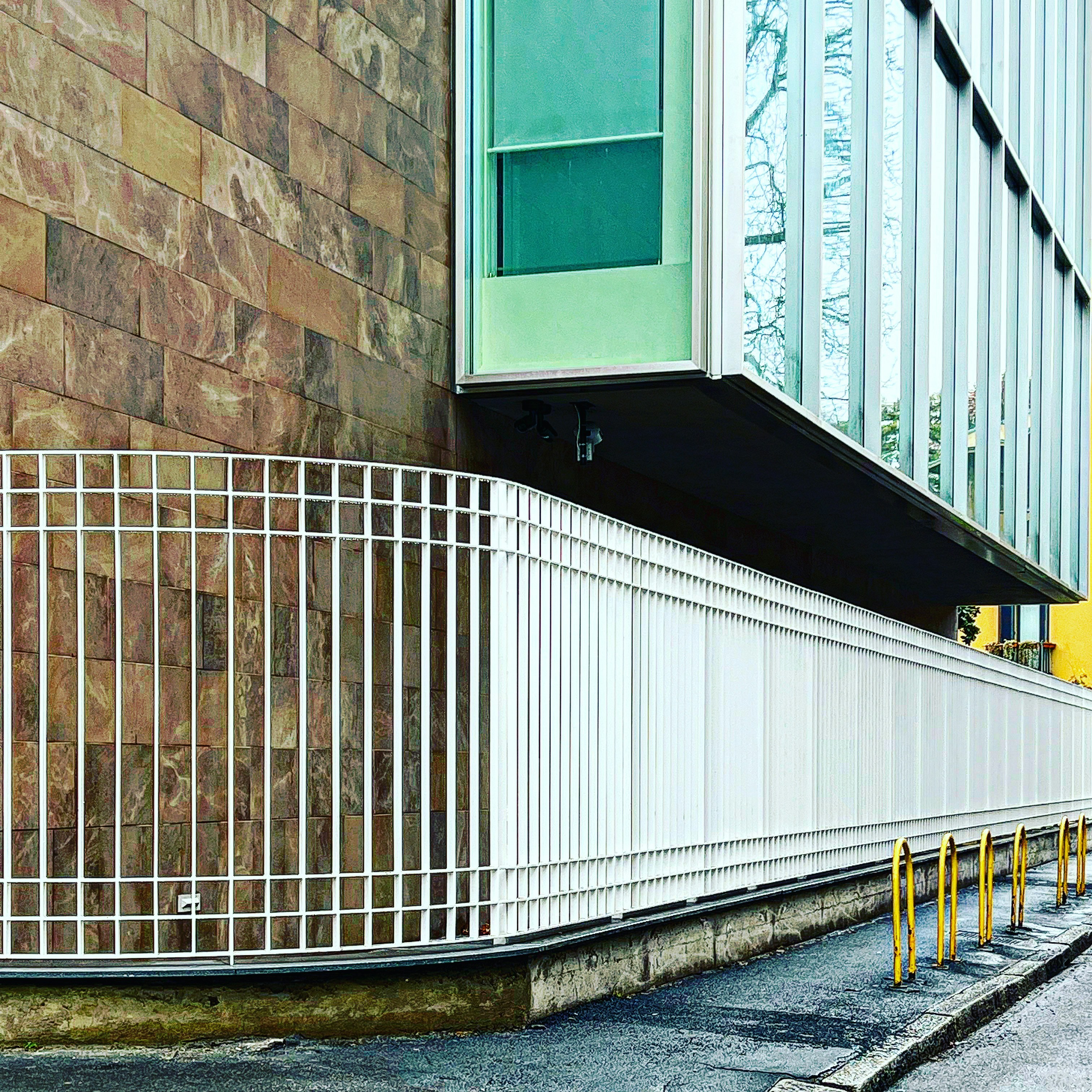 White railing curves along a modern building façade