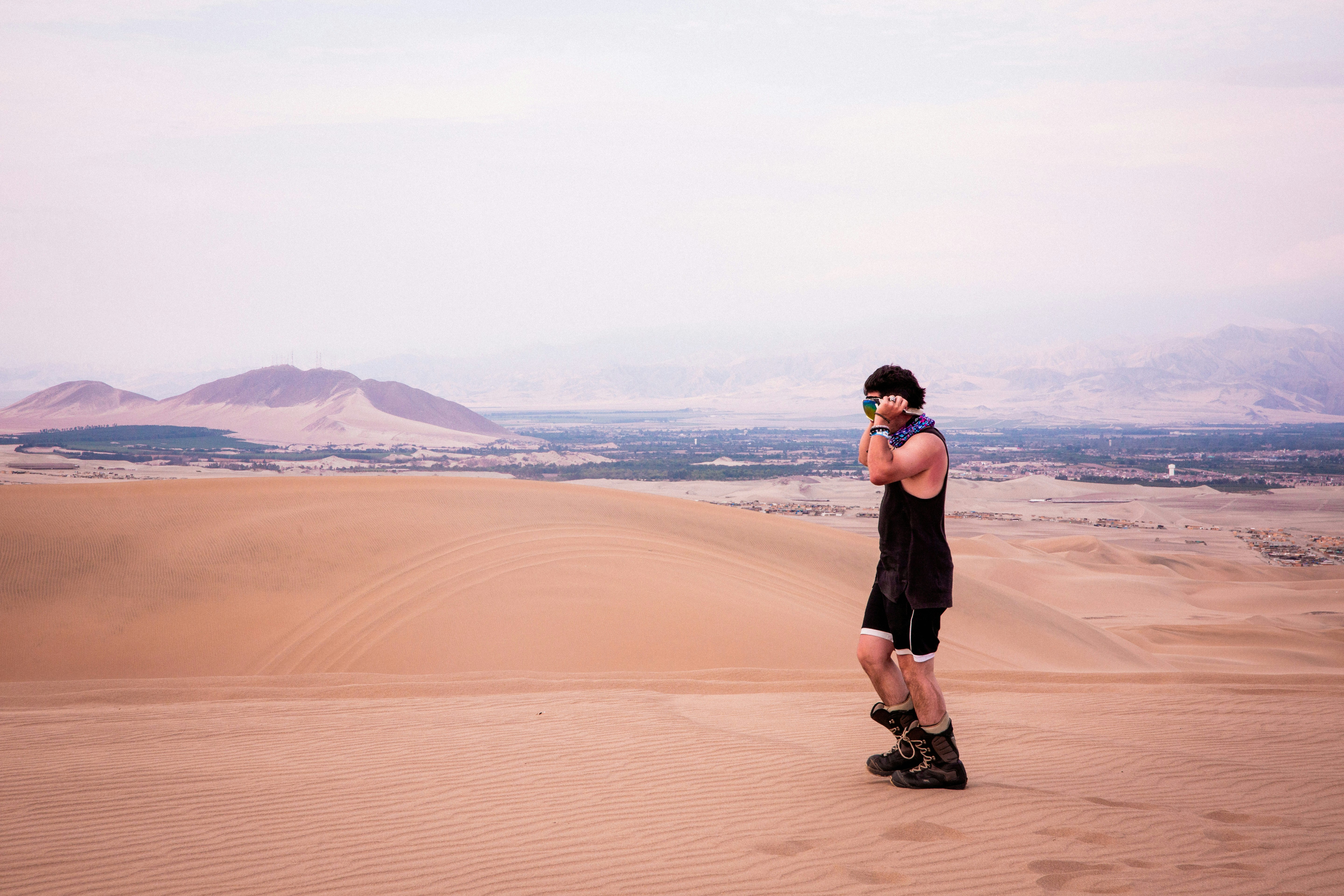 A man standing on top of a sand dune photo – Free Ica Image on Unsplash