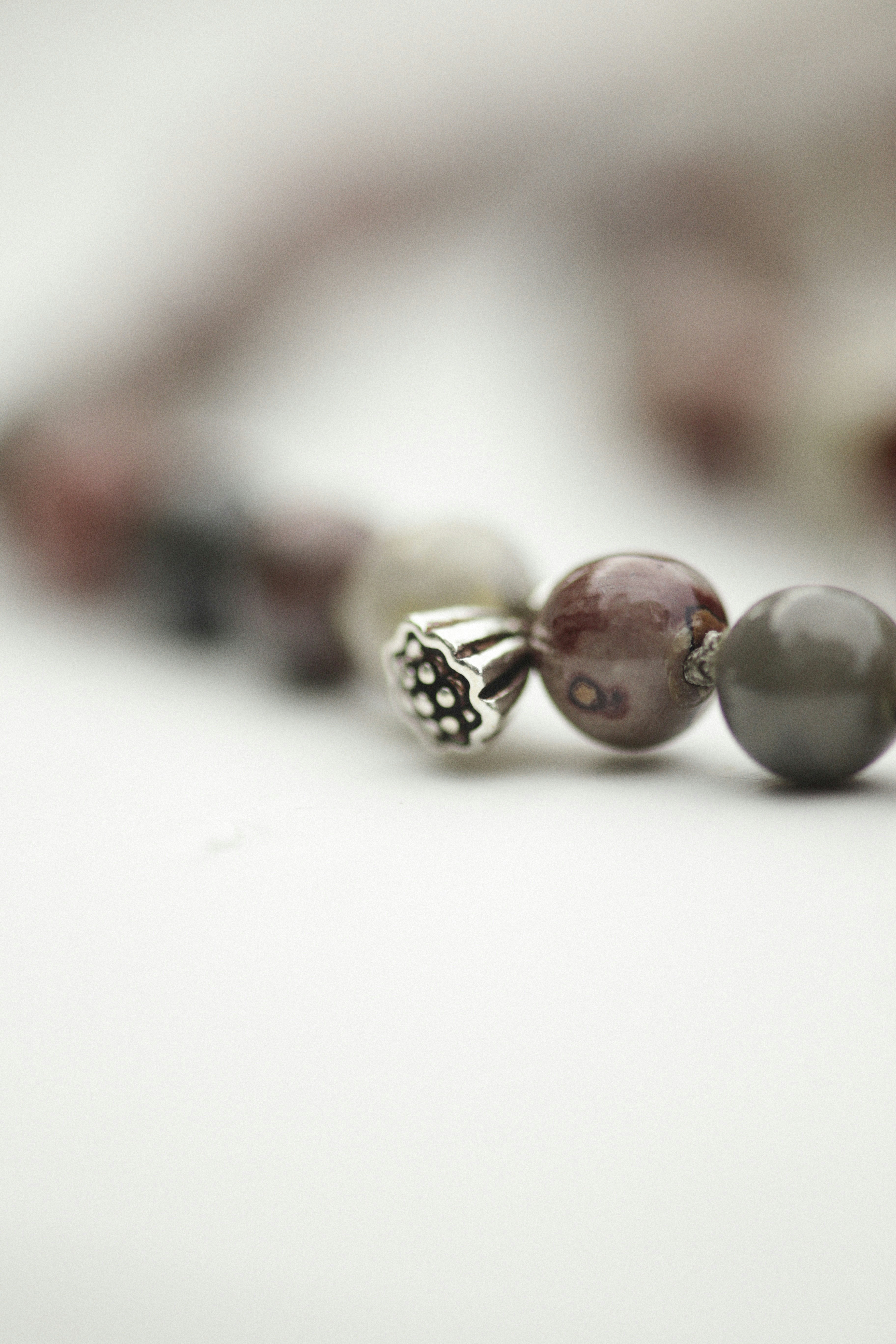 A close up of some beads on a white surface photo – Free Accessory ...