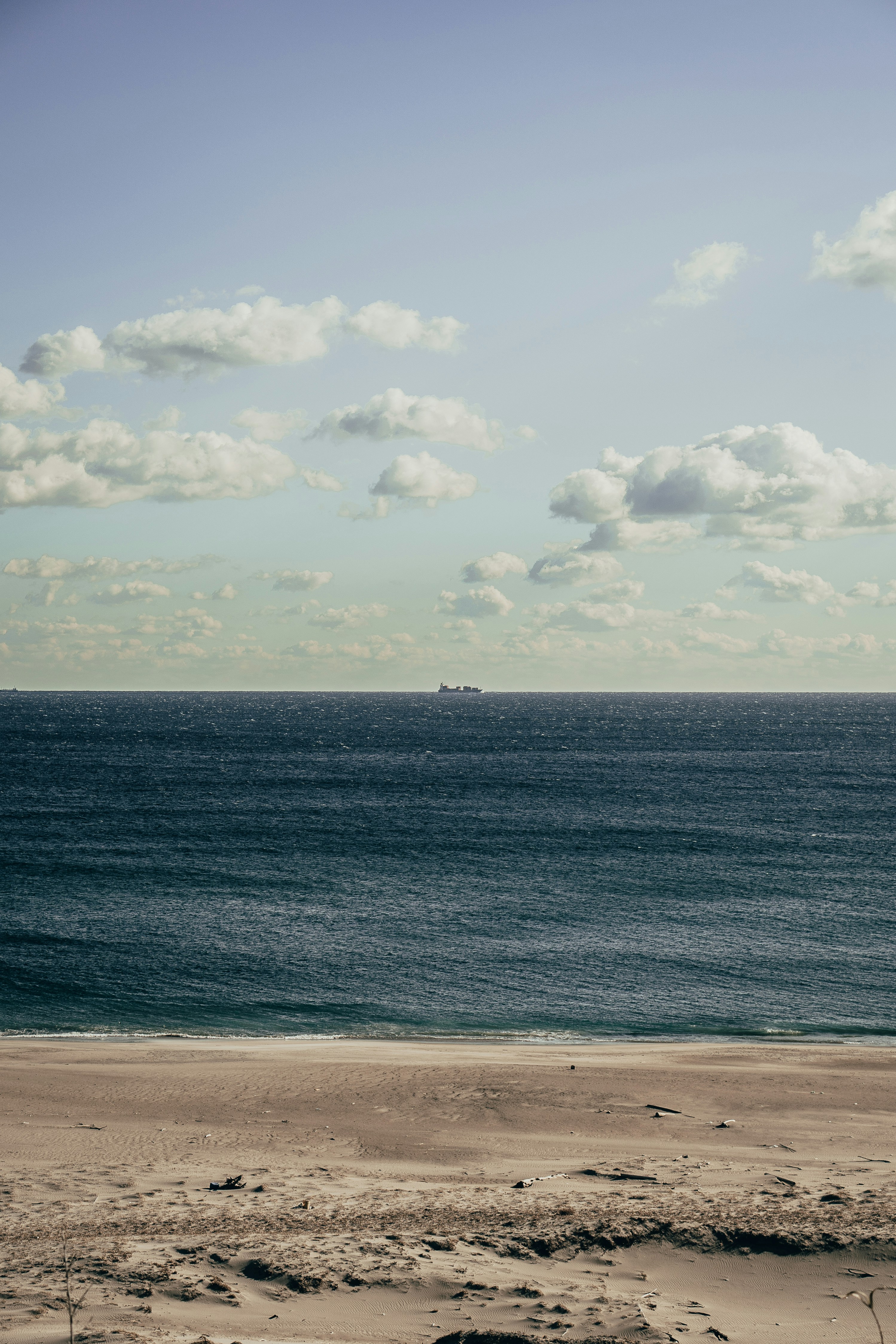A beach with a boat in the distance photo – Free Tahara Image on Unsplash