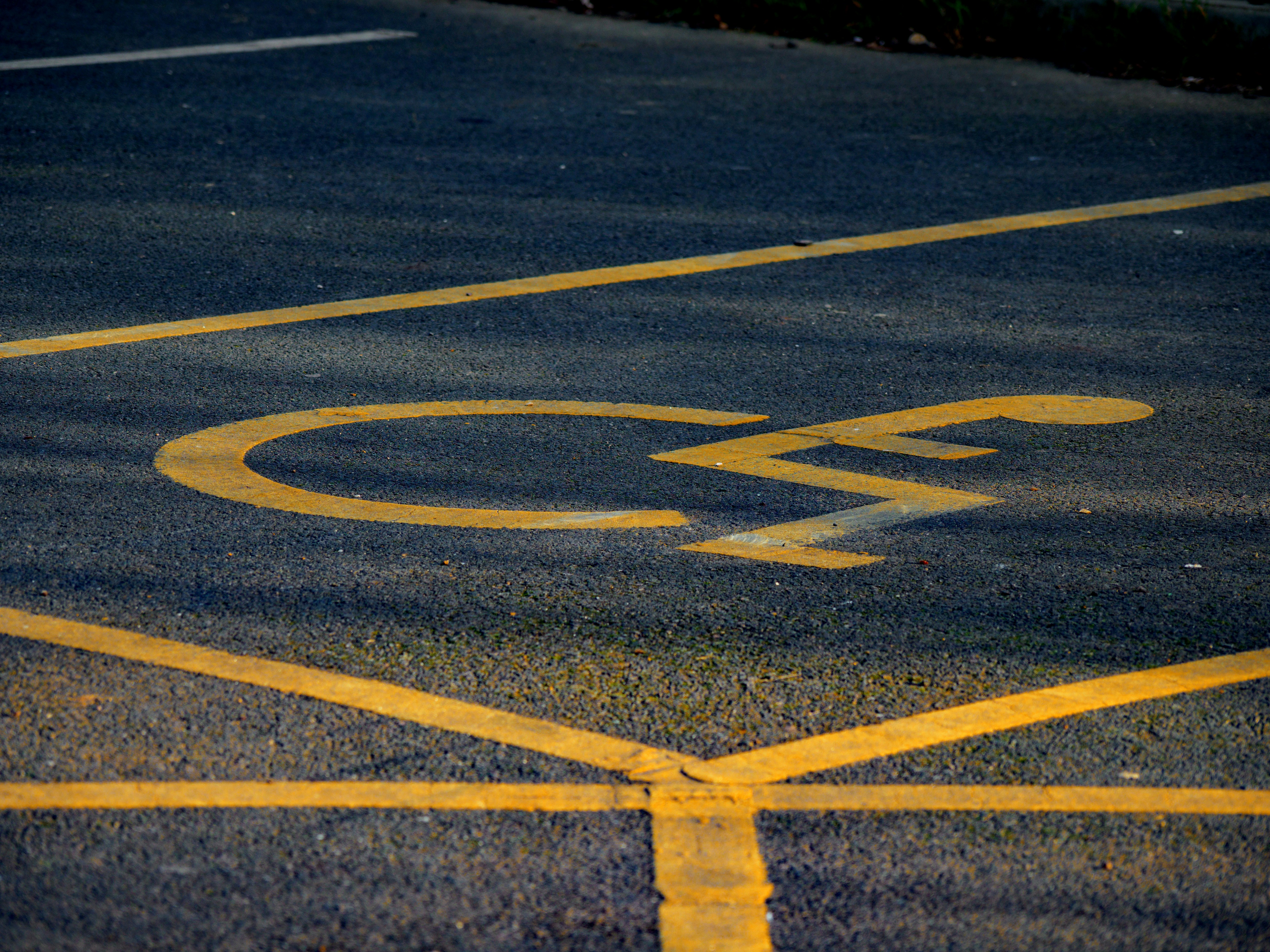 A handicapped sign painted on the asphalt of a parking lot photo – Free ...