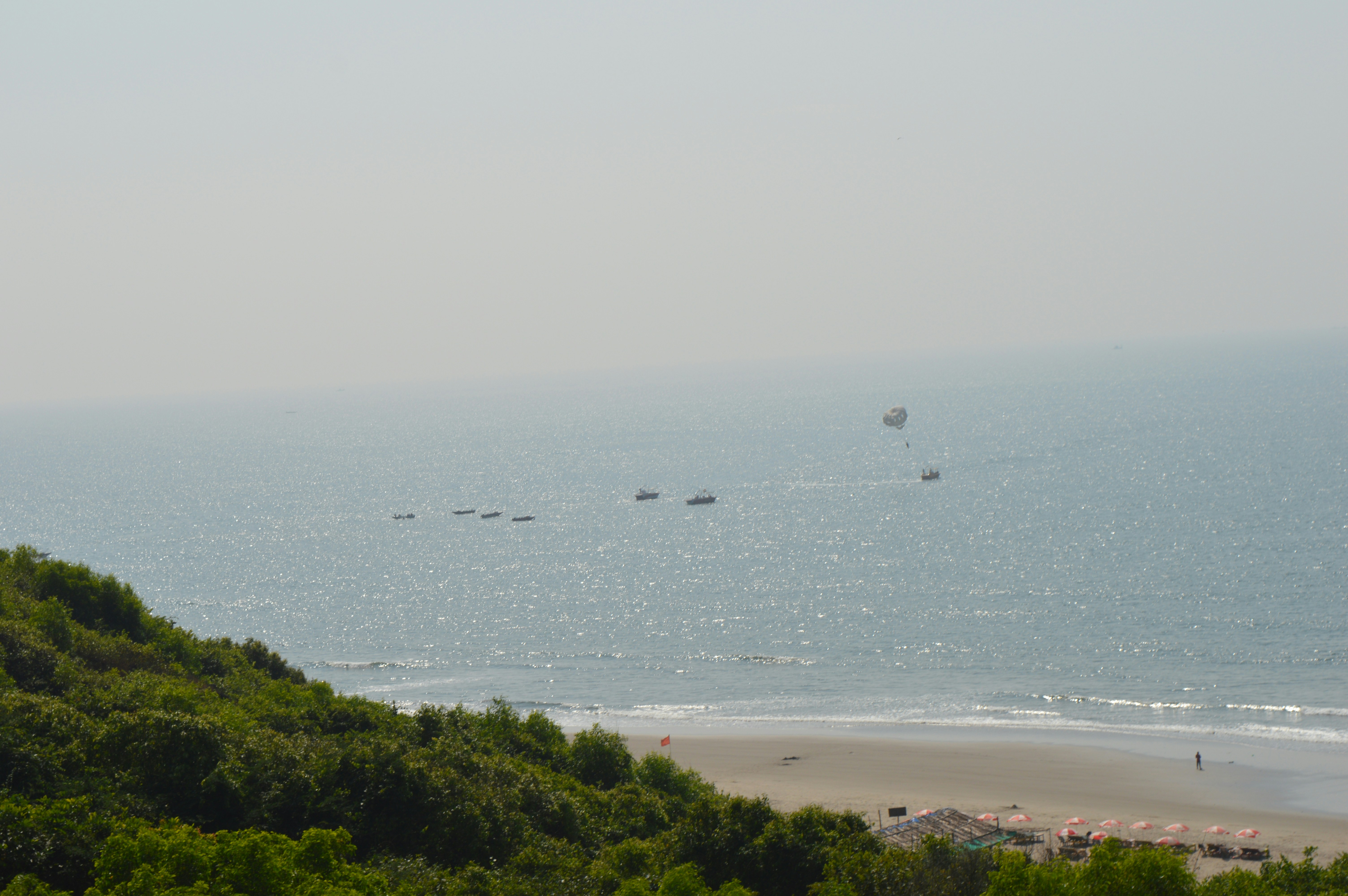 Distant Fleet on a Glassy Sea: Line of Boats Across Sunlit Water