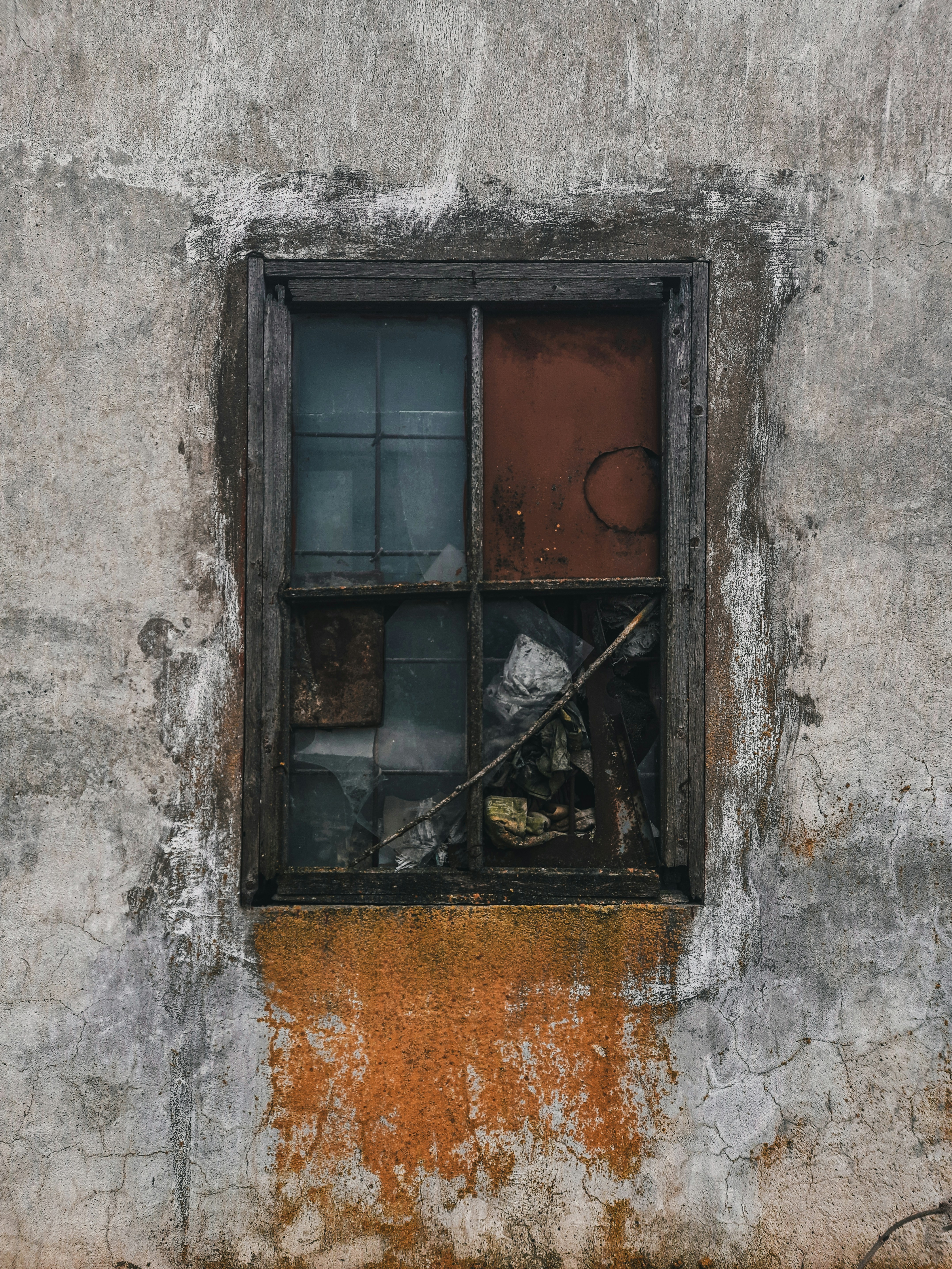 A window with a rusted metal frame on a concrete wall photo – Free ...