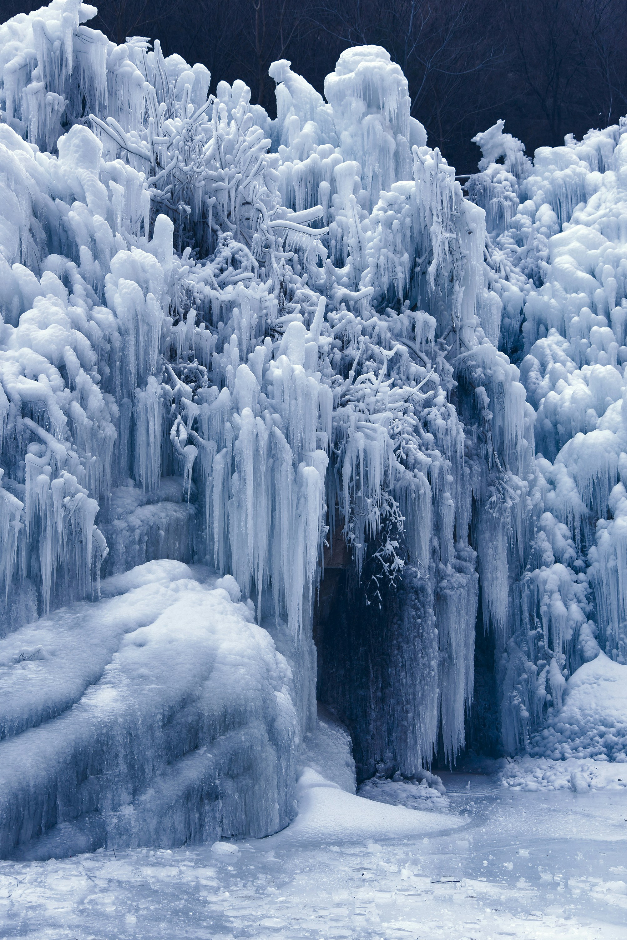 A bunch of icicles that are on the side of a mountain photo – Free ...