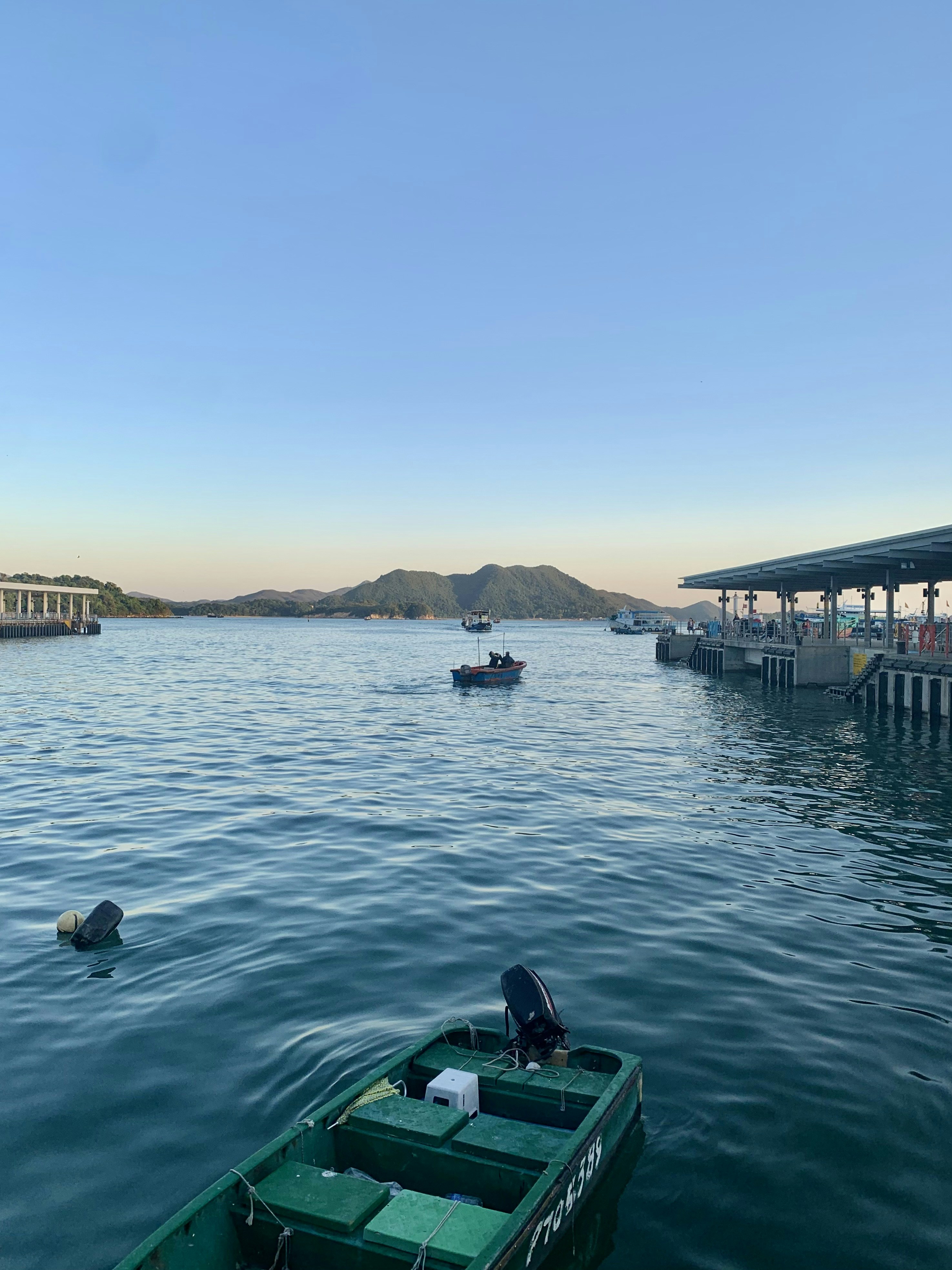 Emerald Workboat at the Edge of a Quiet Harbor, Dusk in the Distance